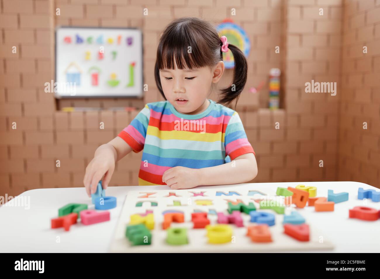 toddler girl learning letter blocks for homeschooling Stock Photo - Alamy