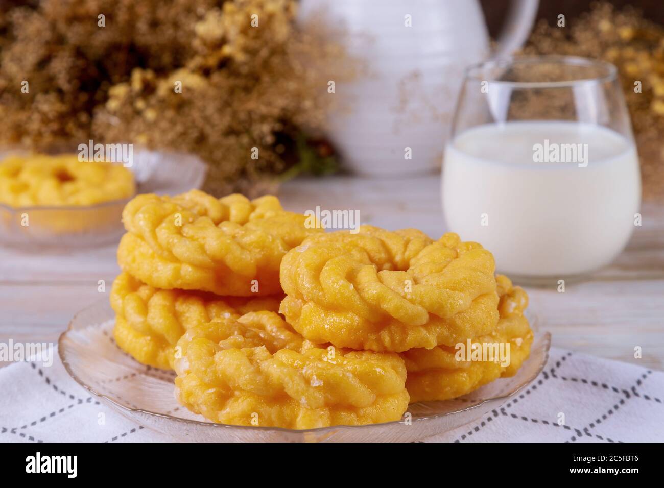 Glazed cruller french donuts with glass of milk on wooden table Stock ...