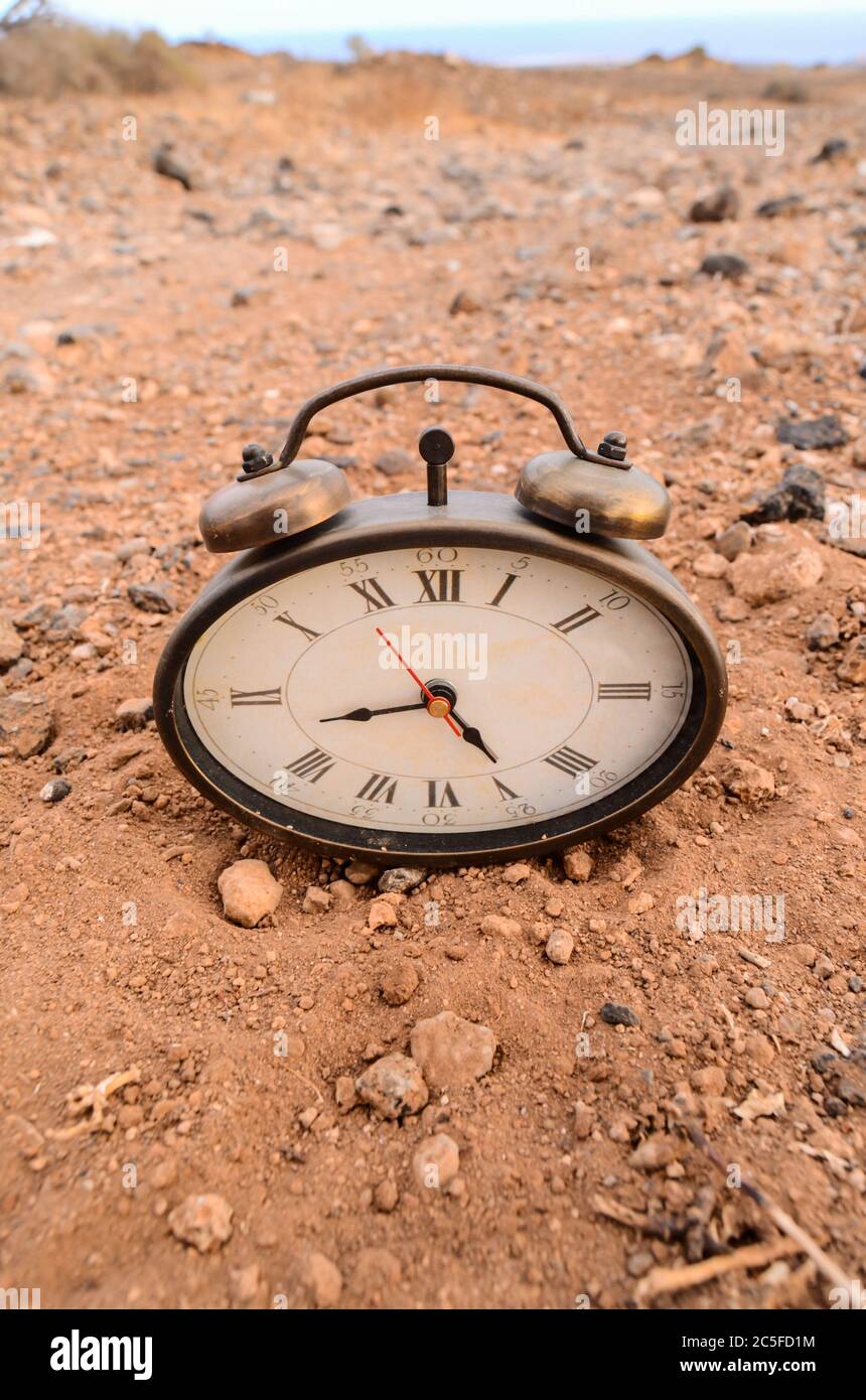 Classic Analog Clock In The Sand On The Rock Desert Stock Photo - Alamy