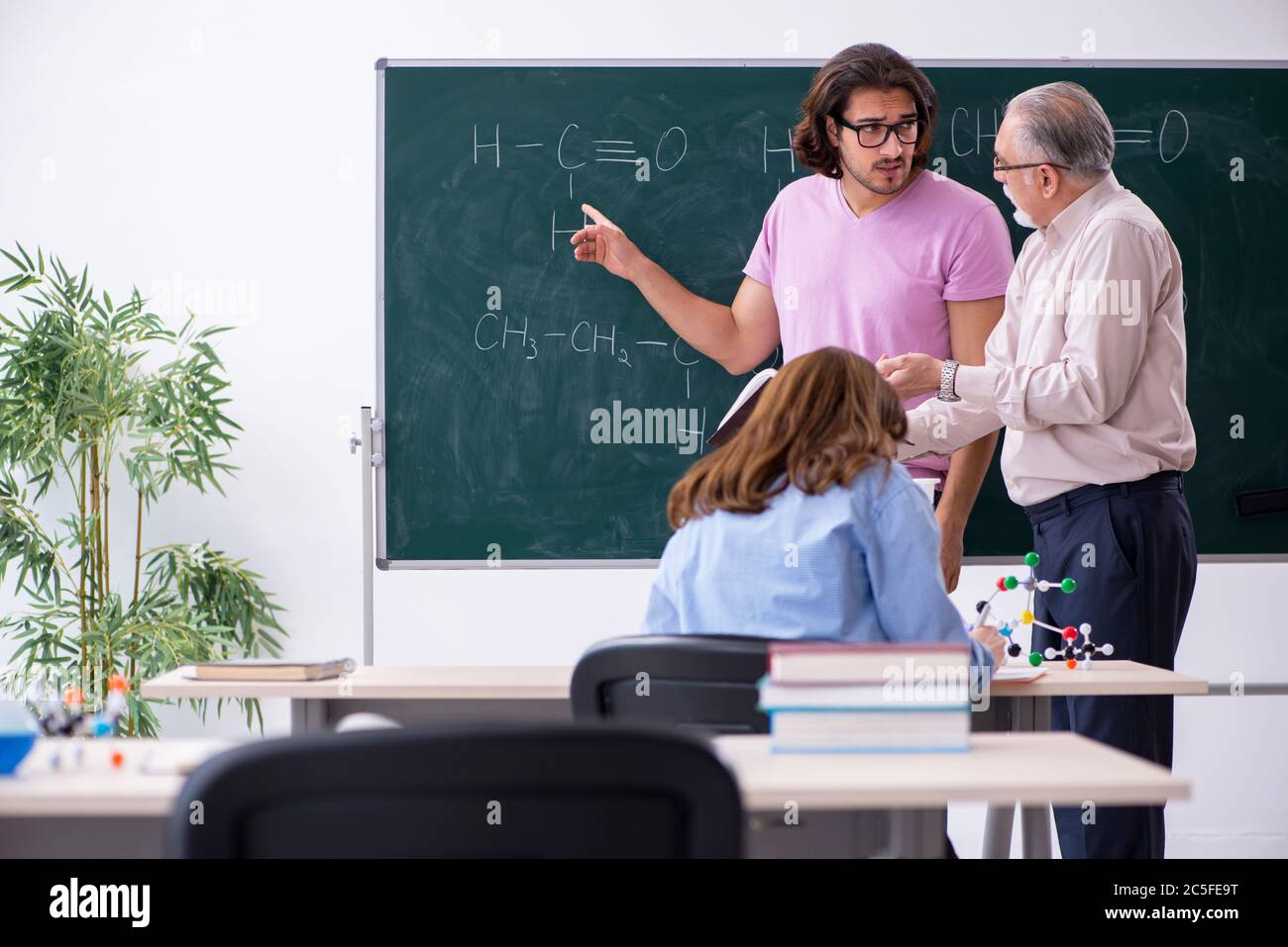 Old teacher and two students in the classroom Stock Photo - Alamy