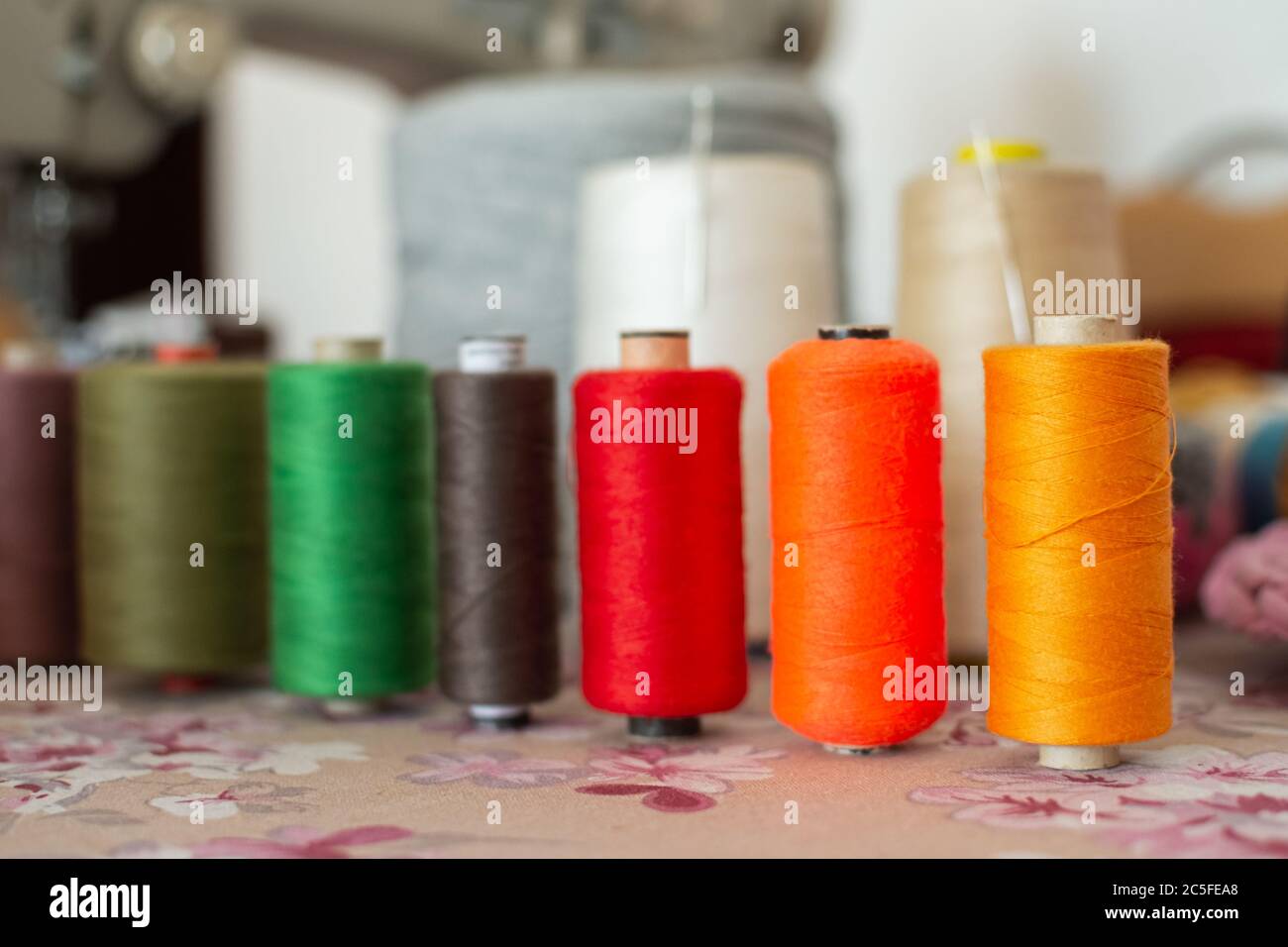 Different colors of threads and sewing machine background Stock Photo ...
