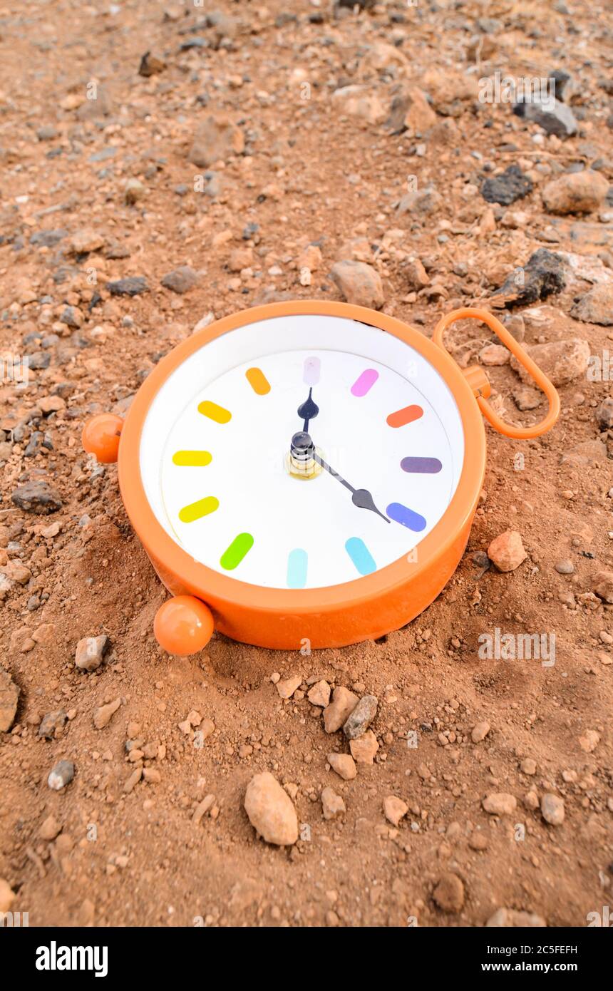 Classic Analog Clock In The Sand On The Rock Desert Stock Photo - Alamy