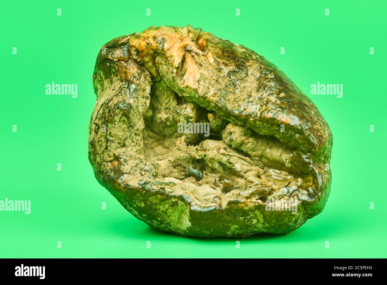 Rotten lemon, green background. Mold putrefied fruit yellow and green ...