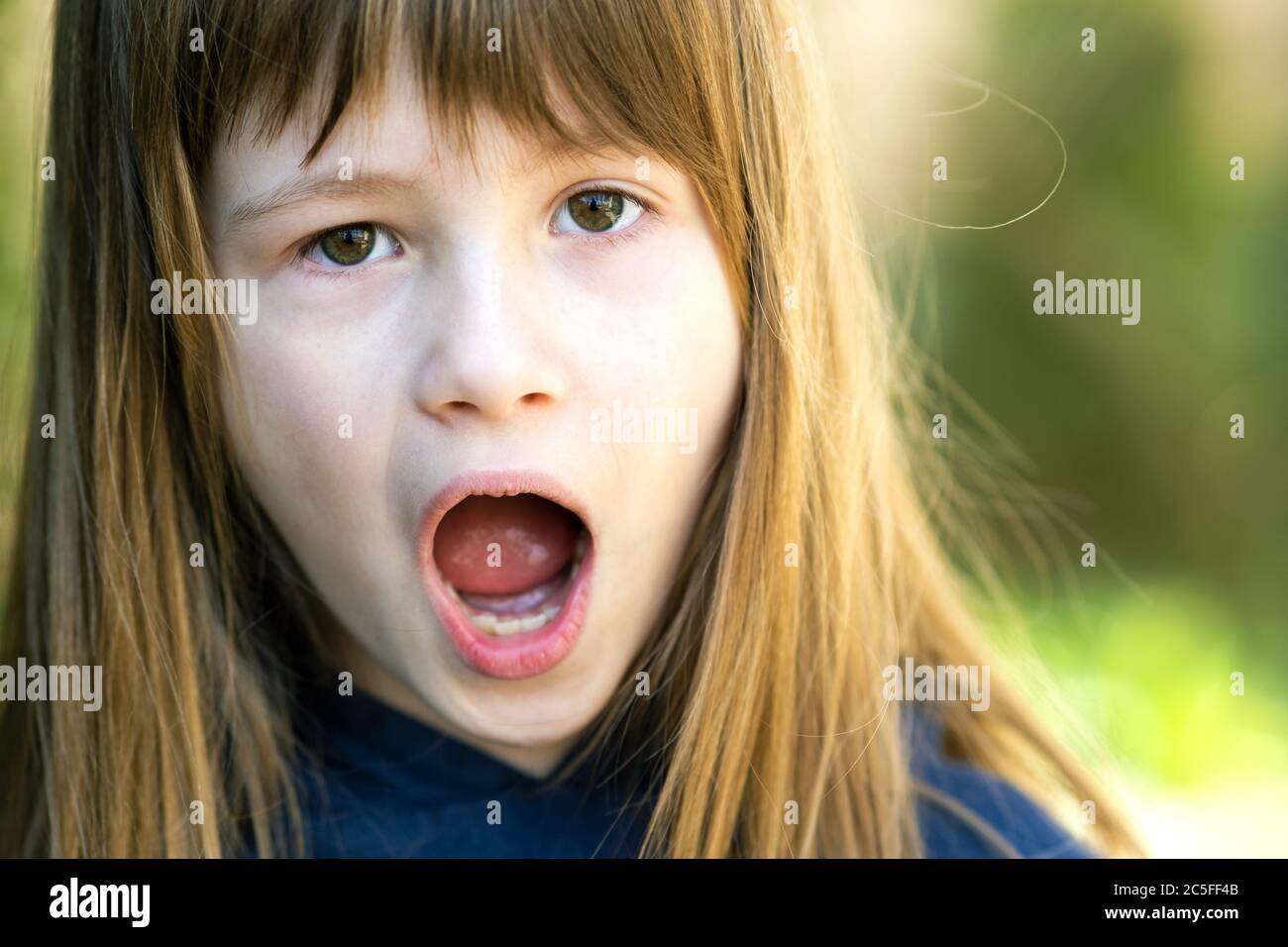 Portrait of surprised child girl outdoors in summer. Shocked female kid ...