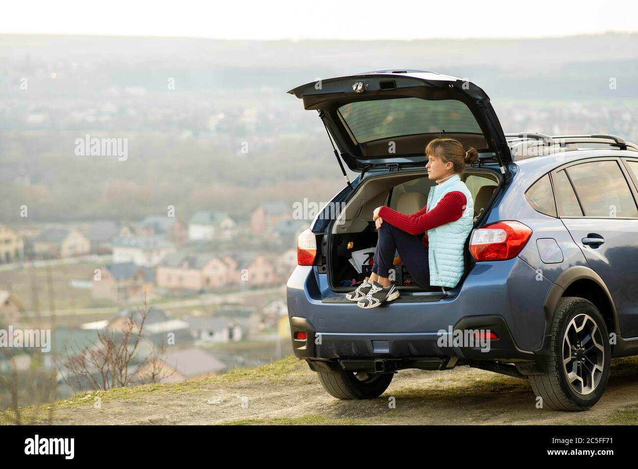 Young woman driver sitting alone in her car enjoying view of nature ...