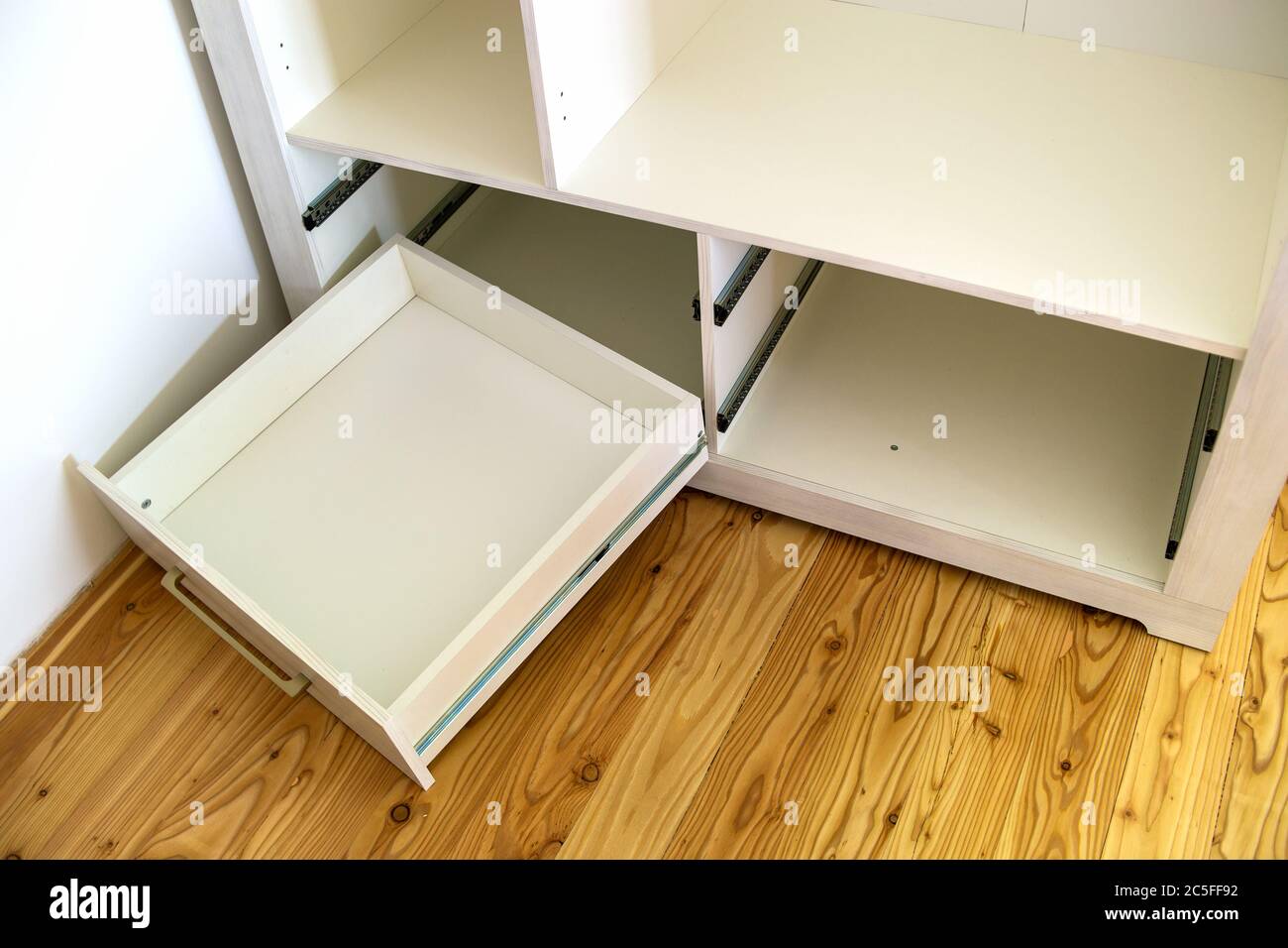 Close up of installation of wooden drawer in contemporary cupboard ...