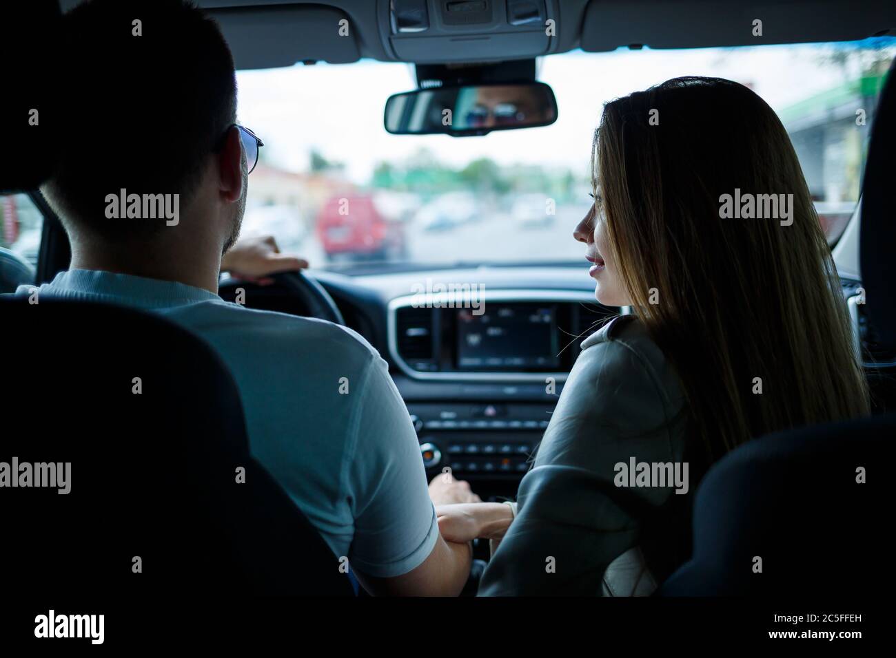 Loving couple in a car hug and hold hands while traveling. Stylish ...