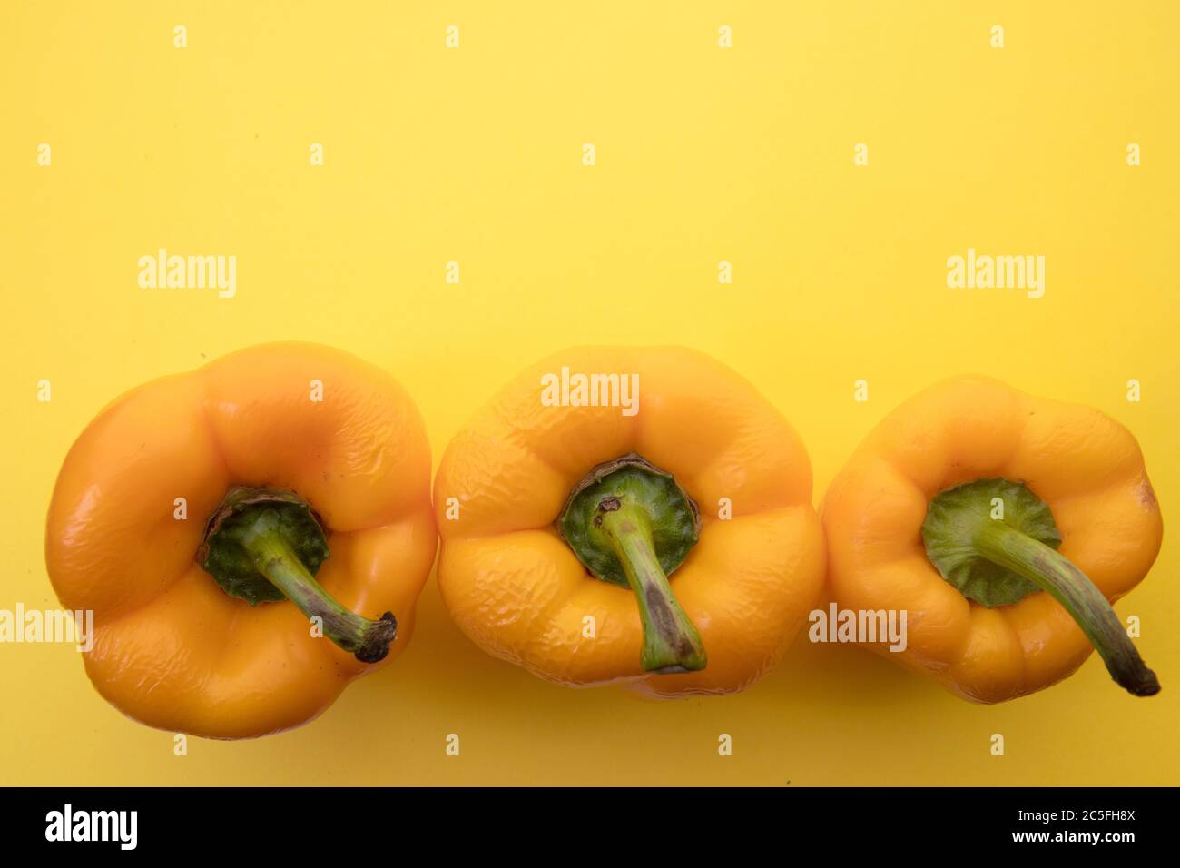 Old pepper, spoiled food. On a yellow background. The passage of time ...