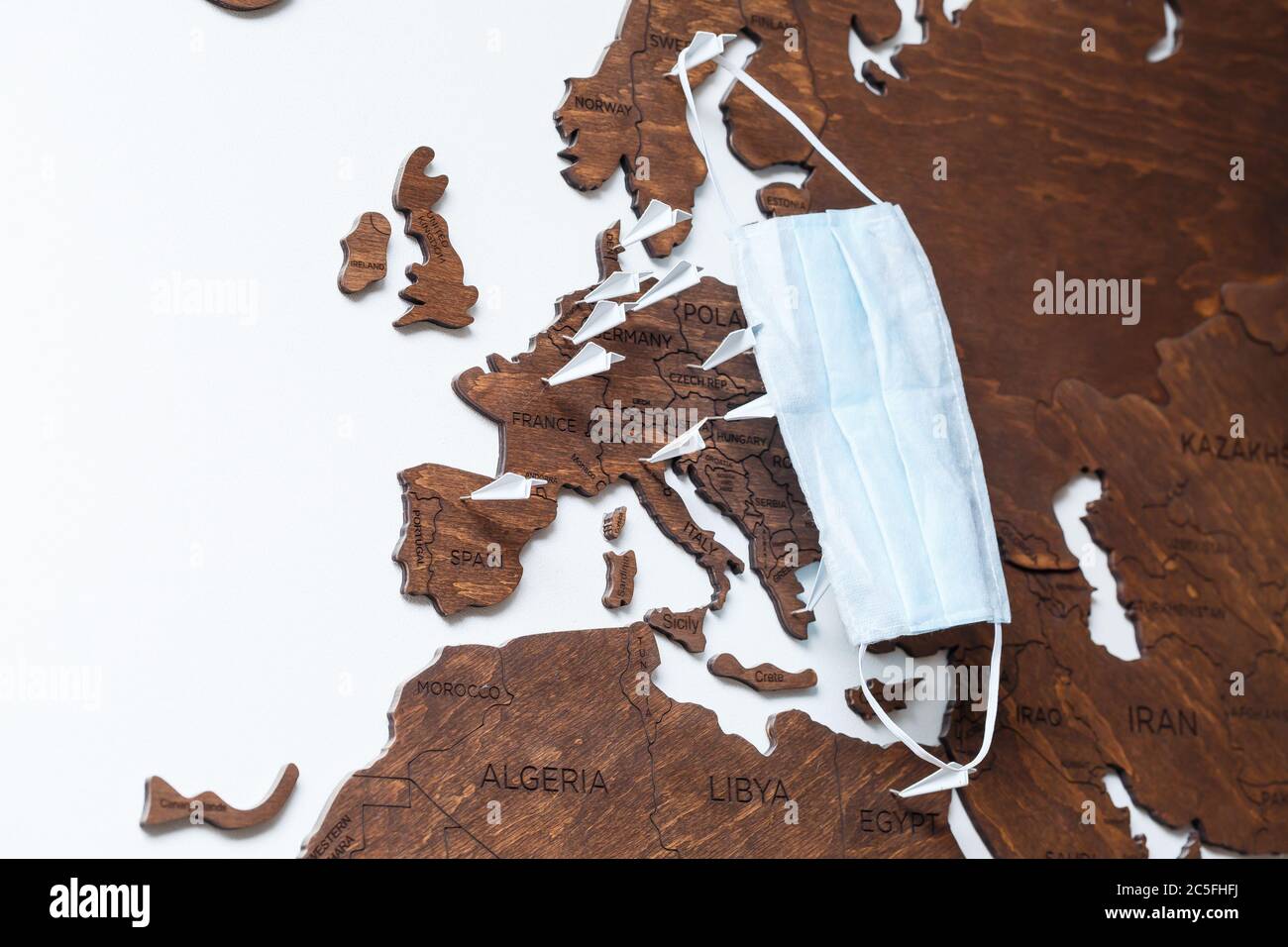 Protective antiviral mask is dressed on a wooden map of the world Stock ...