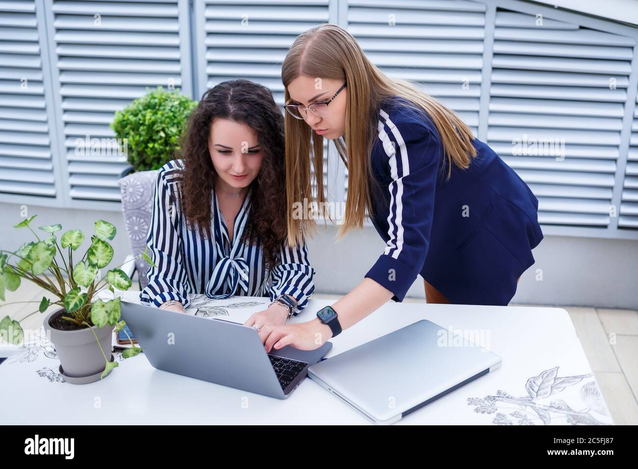 Two serious businesswomen girls discussing a business project, working ...