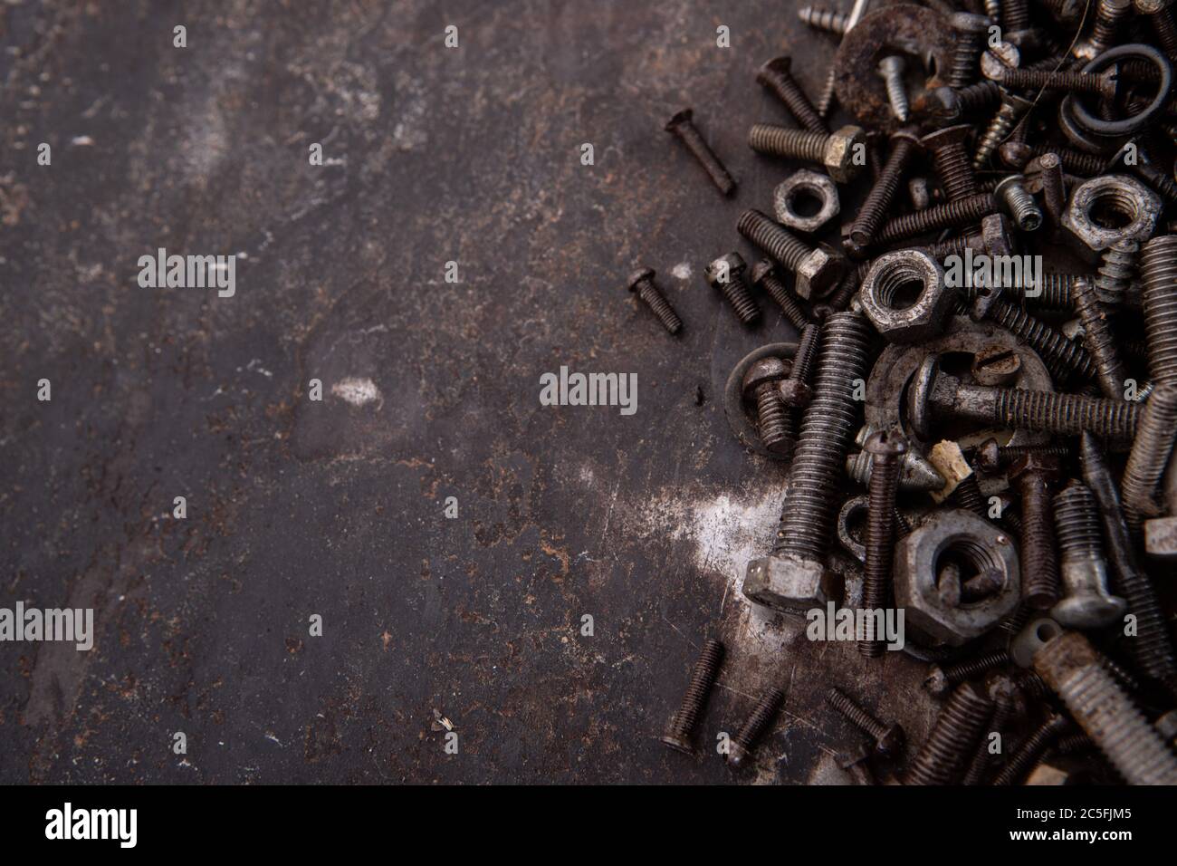 old nuts, screws and nails greasy and dirty heavily rusted lie on a ...