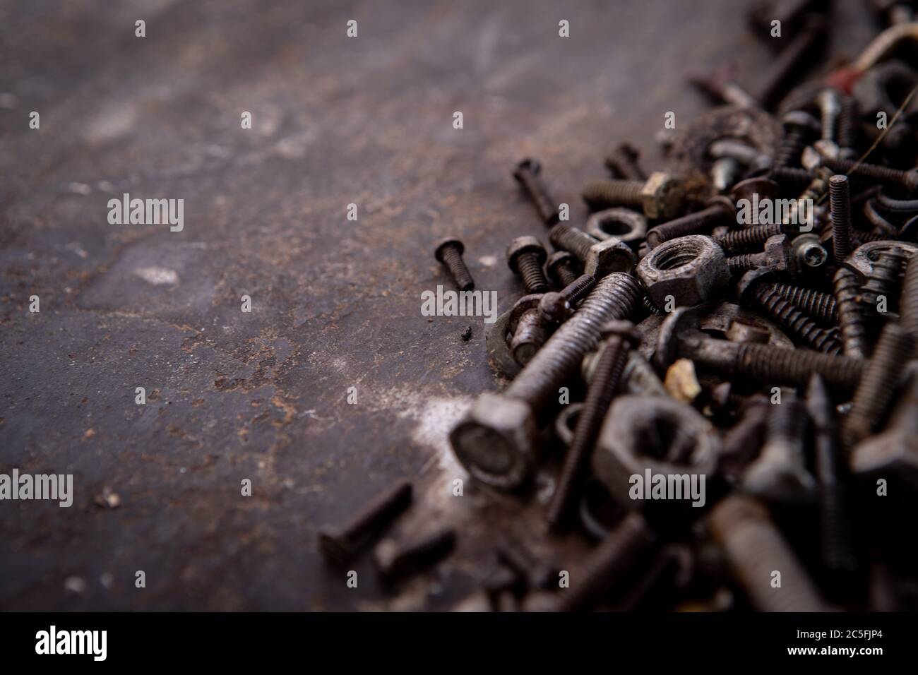 old nuts, screws and nails greasy and dirty heavily rusted lie on a ...