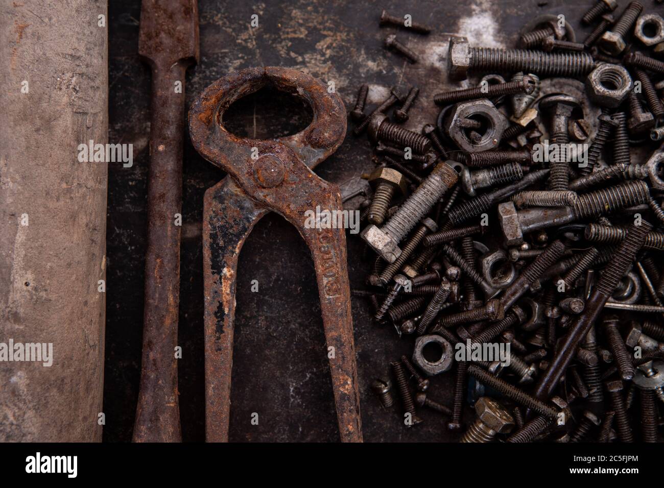old nuts, screws and nails greasy and dirty heavily rusted lie on a ...