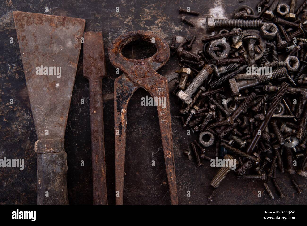 old nuts, screws and nails greasy and dirty heavily rusted lie on a ...