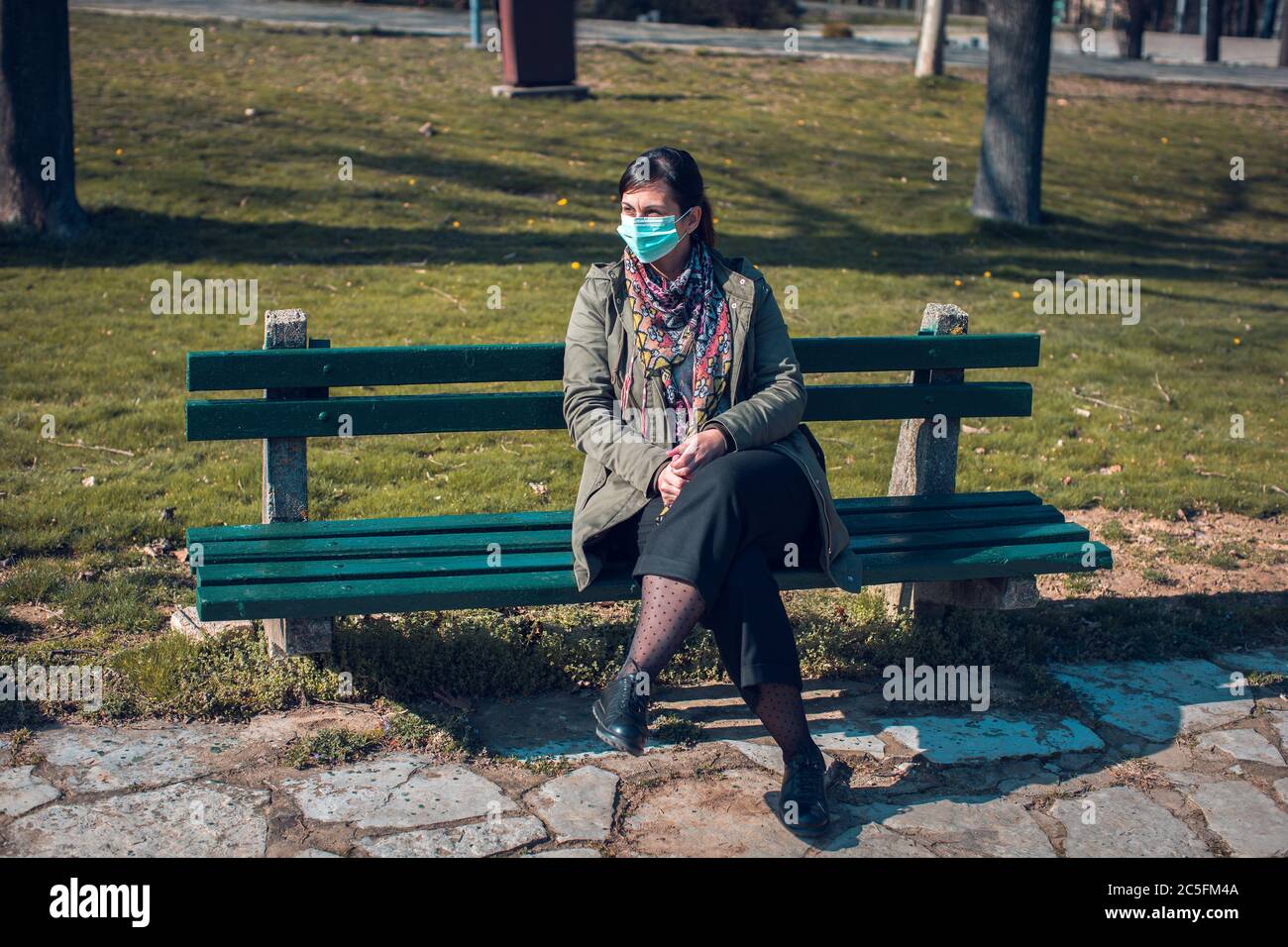 woman with face mask sitting alone on park bench Stock Photo - Alamy