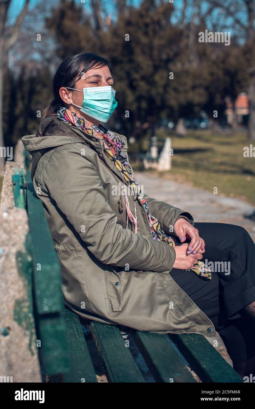 woman with face mask sitting alone on park bench Stock Photo - Alamy