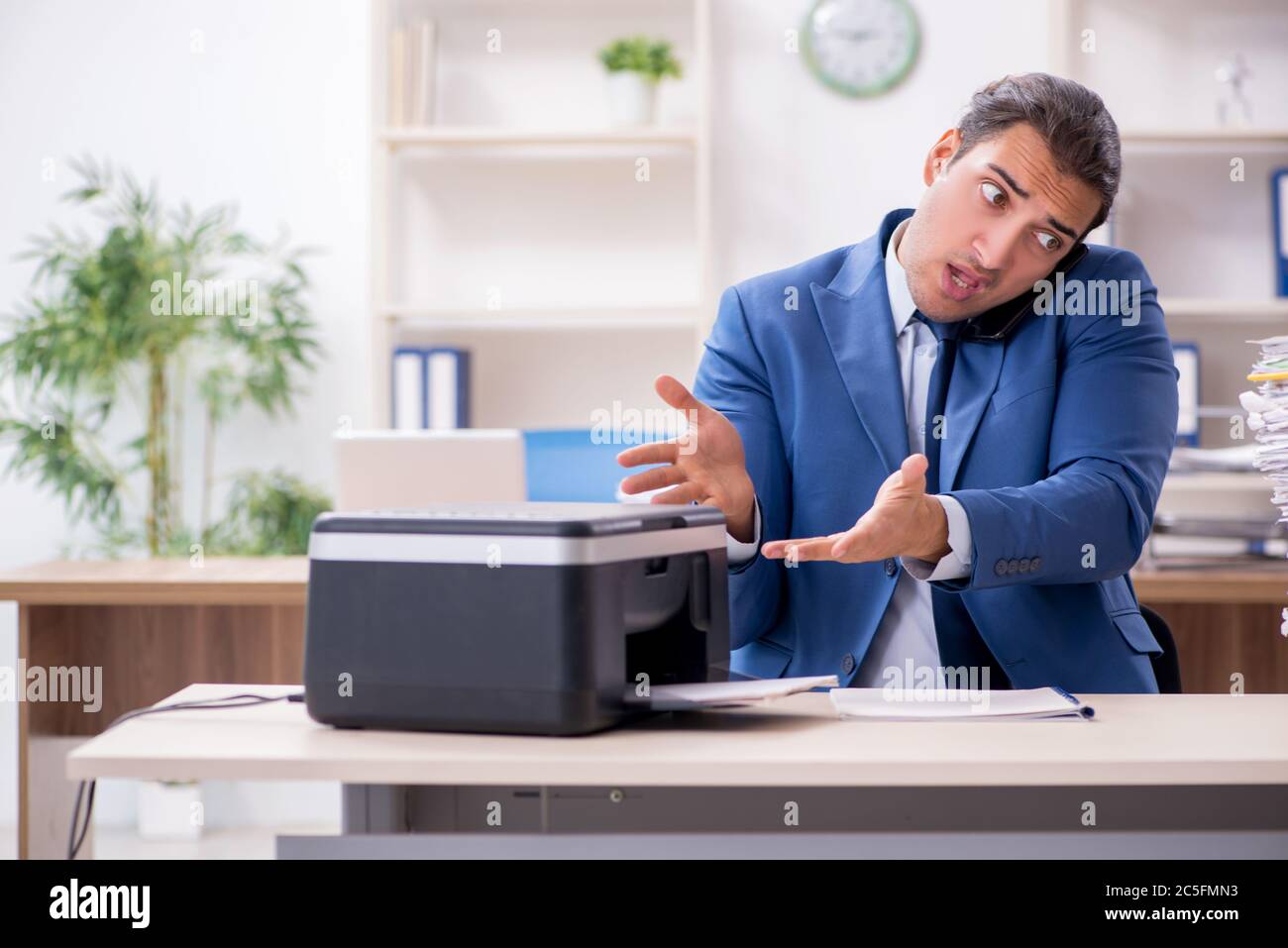 Young employee making copies at copying machine Stock Photo - Alamy