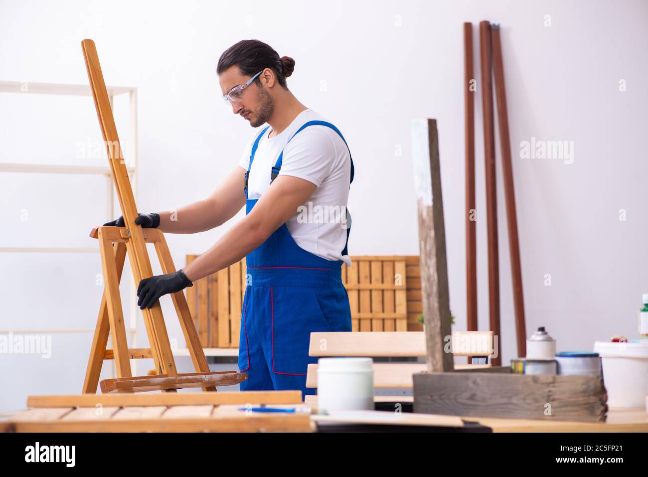 Young male contractor working in the workshop Stock Photo - Alamy