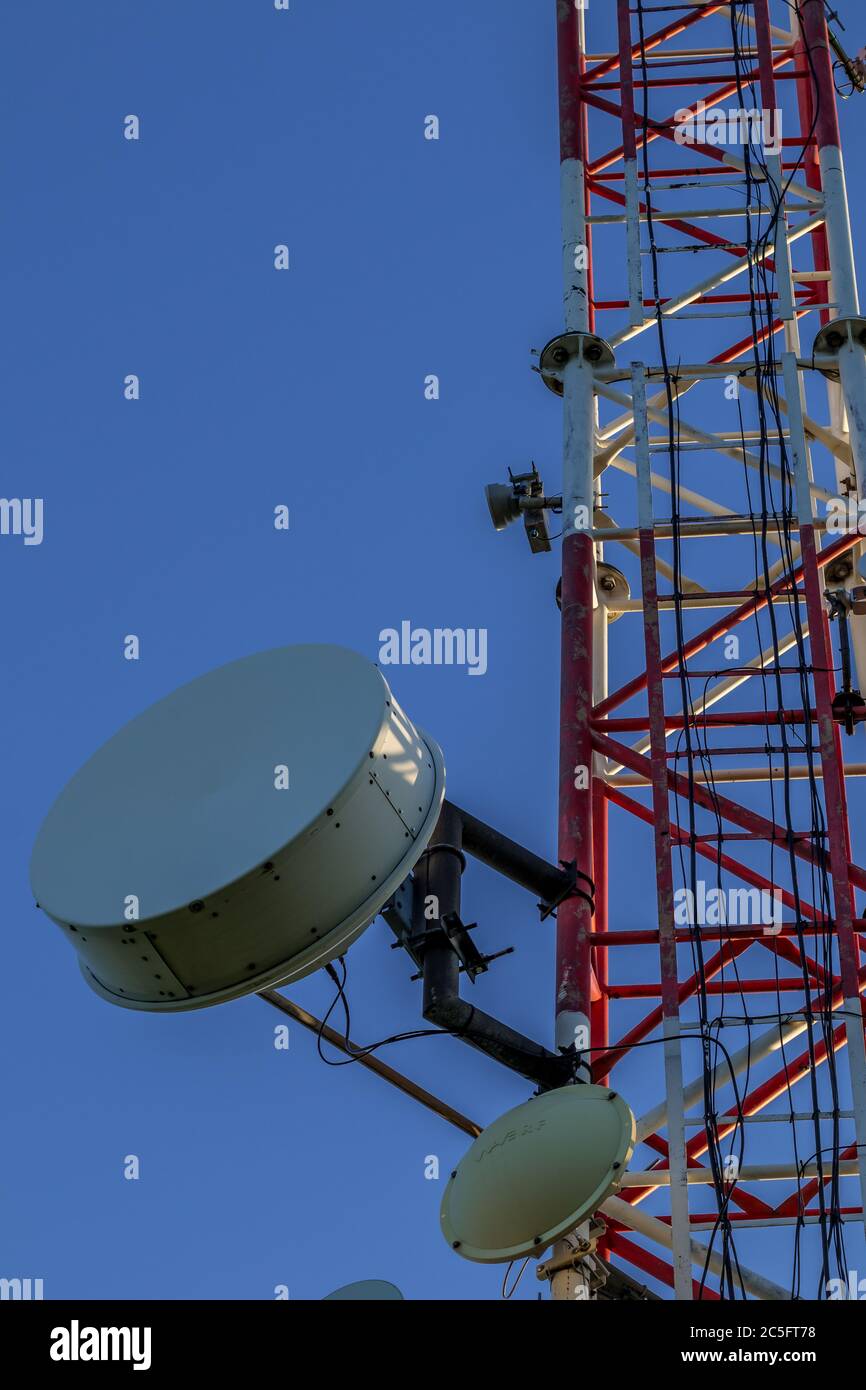 Closeup of a broadcast tower full of devices with a blue sky in the ...