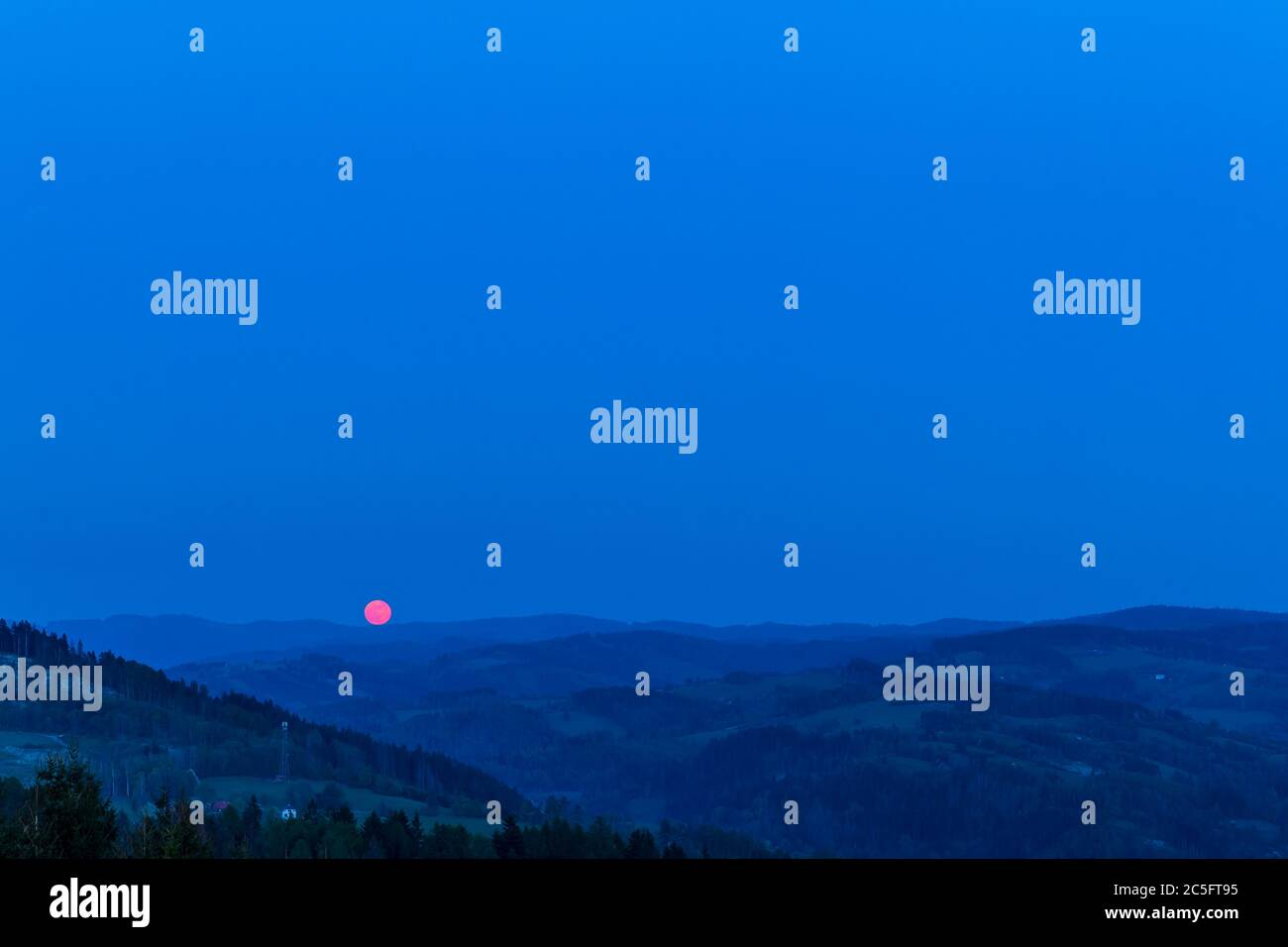 Red moon rising from a mountain area after sunset Stock Photo - Alamy