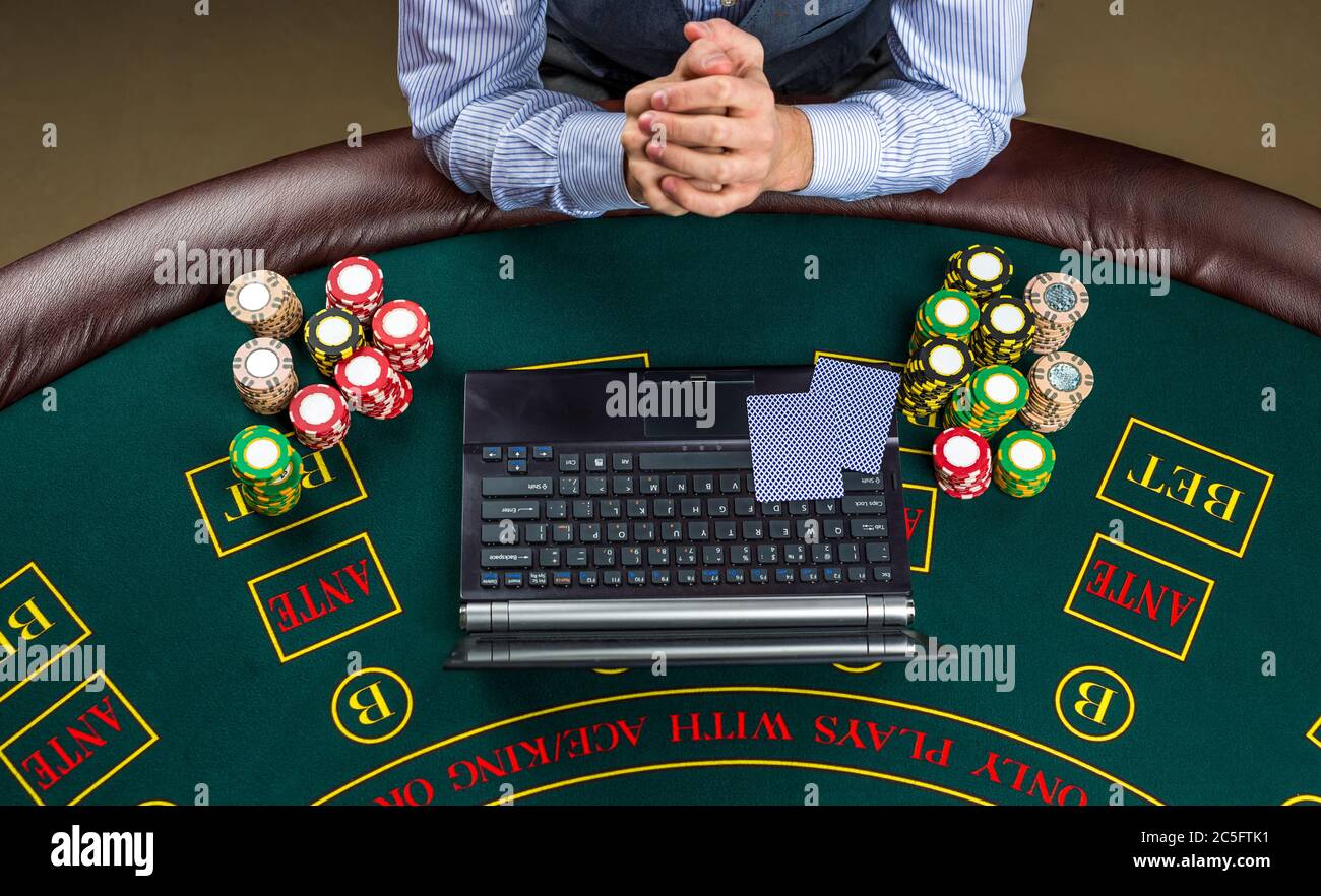 Closeup of poker player with playing cards, laptop and chips Stock ...