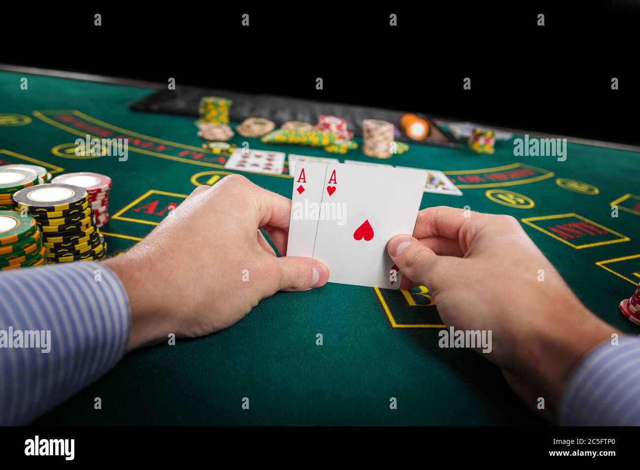 Male poker player holding the of two cards aces Stock Photo - Alamy