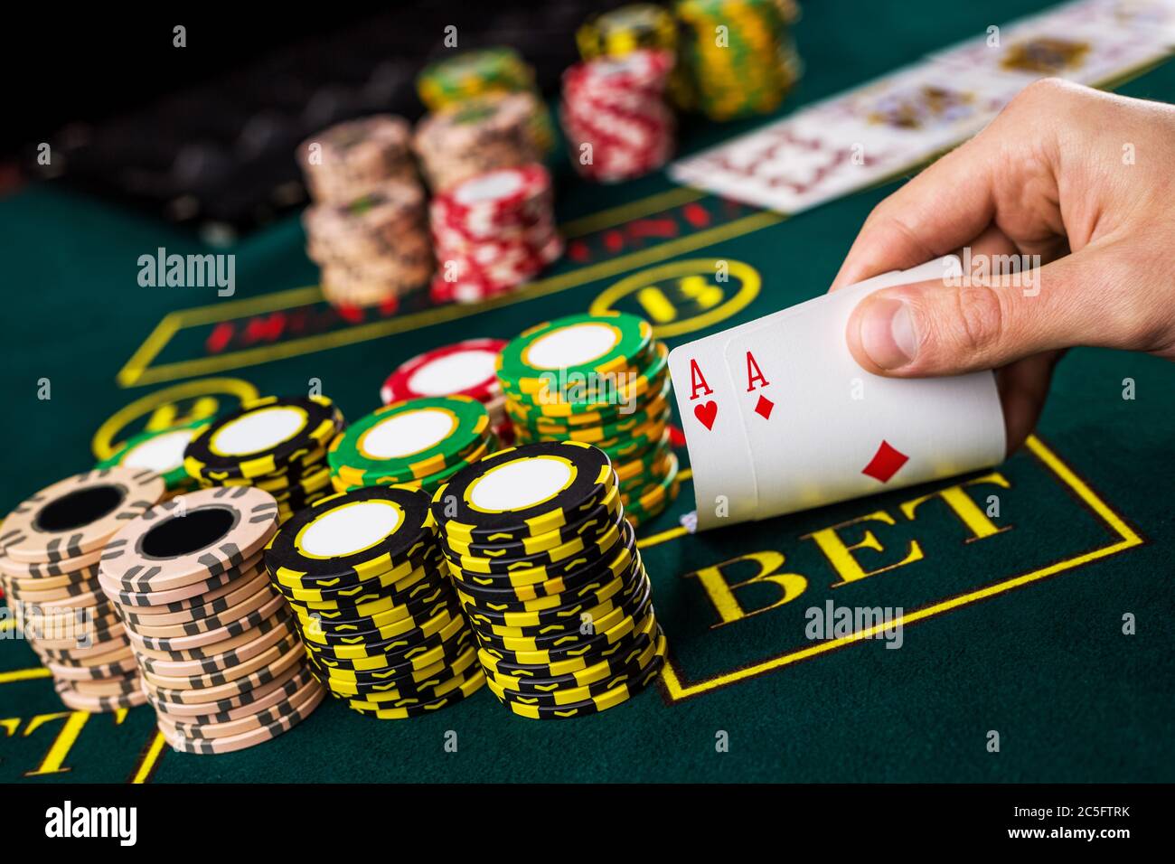 Male poker player lifting the corners of two cards aces Stock Photo - Alamy