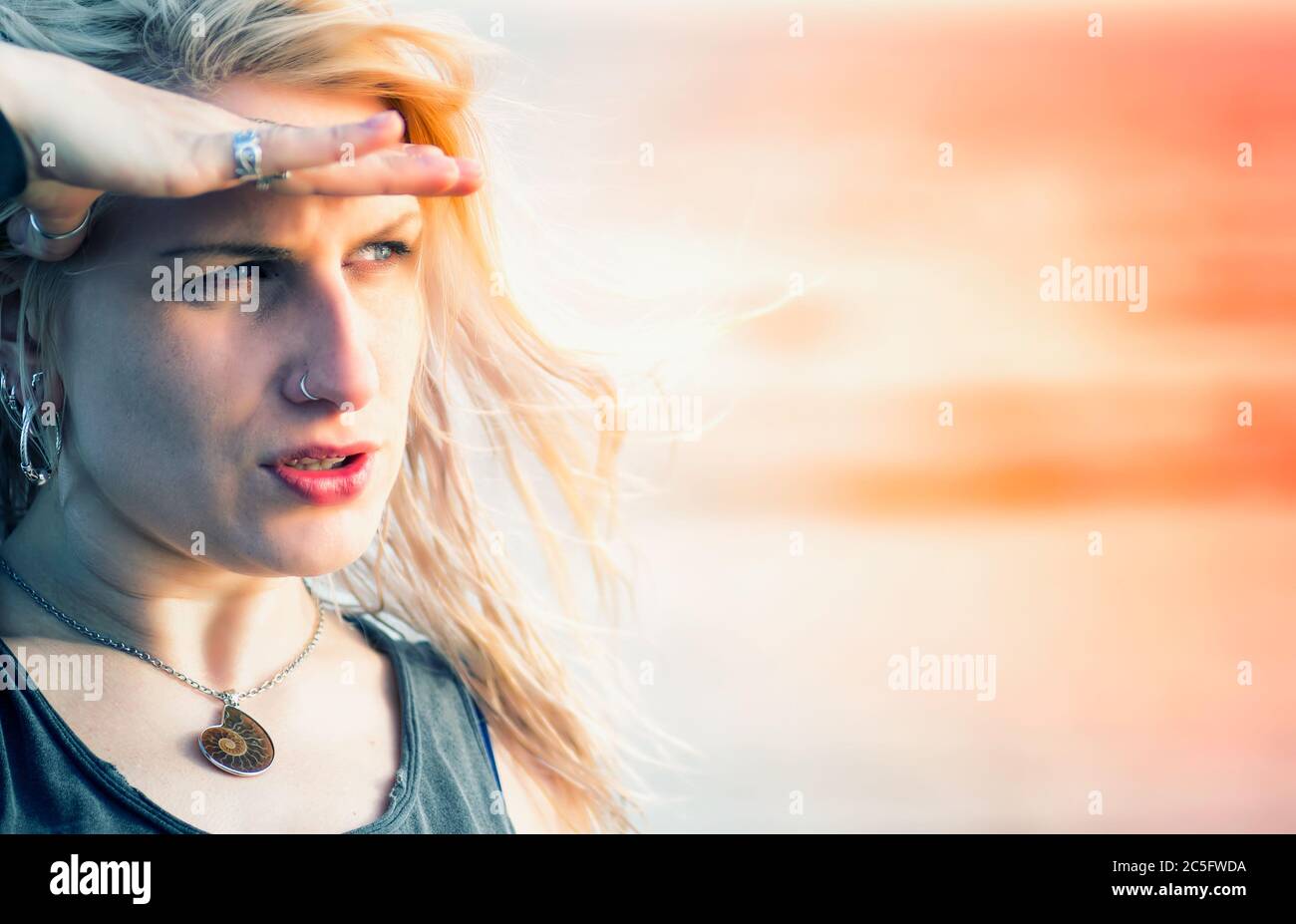 Blonde woman with a piercing looking into the distance Stock Photo - Alamy