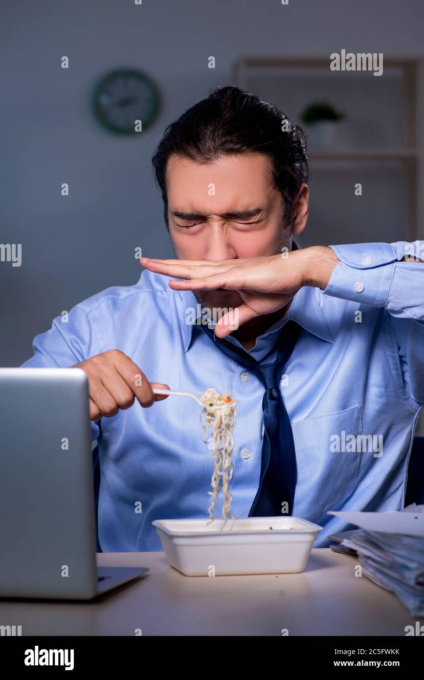 Hungry employee working late in office Stock Photo - Alamy