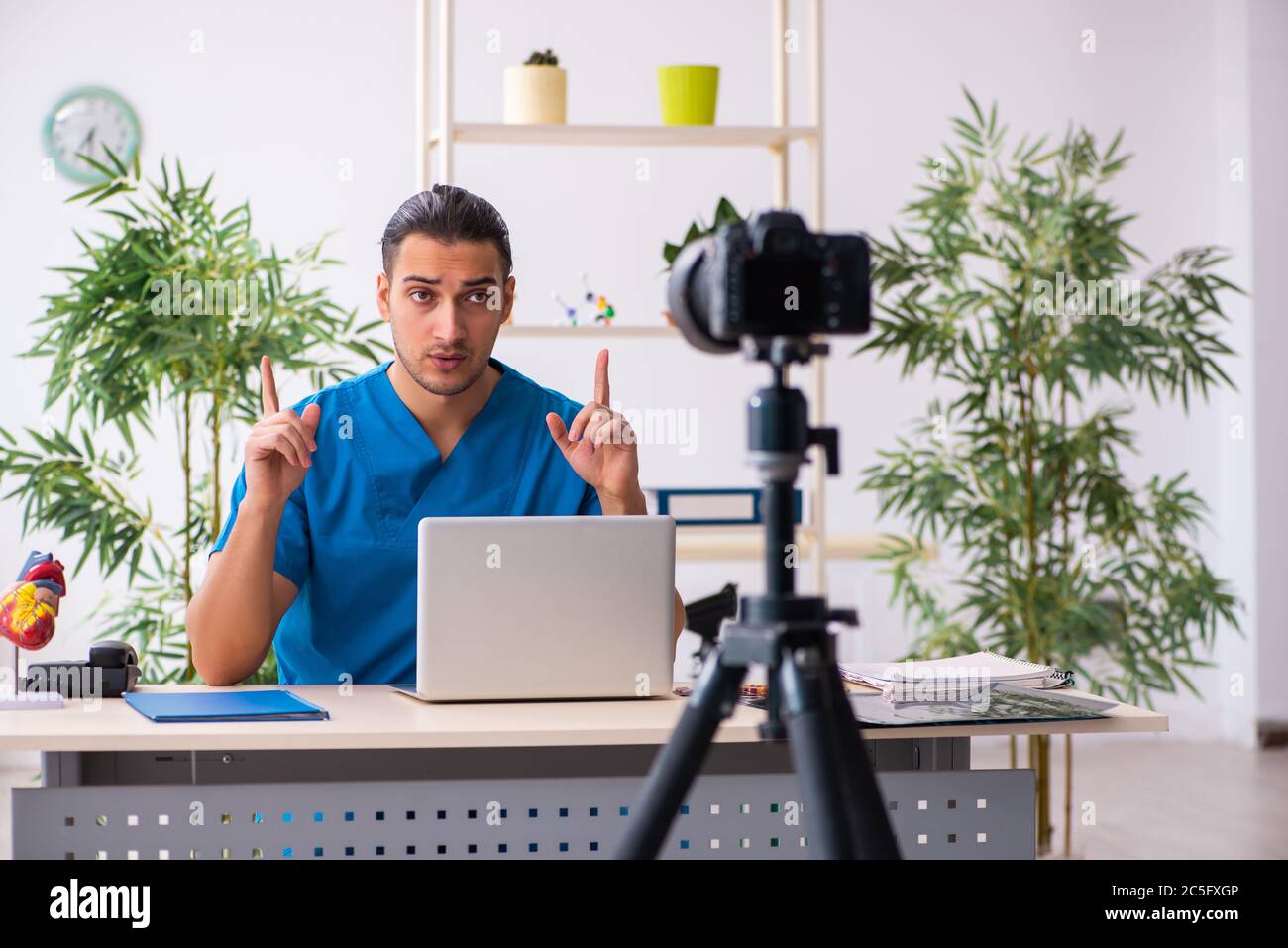 Young doctor recording video for his blog Stock Photo - Alamy