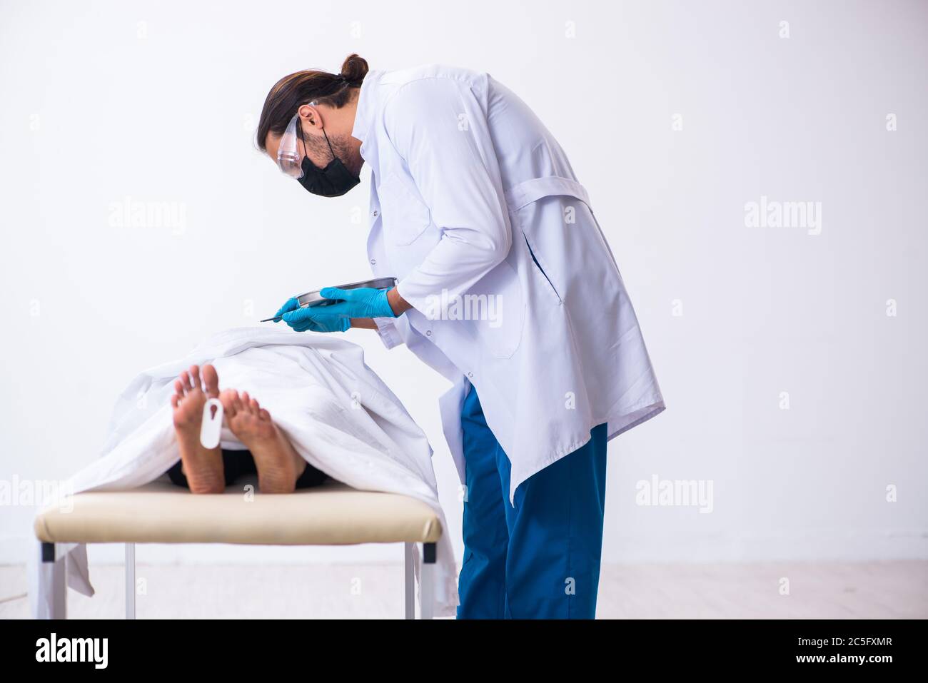 Police coroner examining dead body in morgue Stock Photo - Alamy