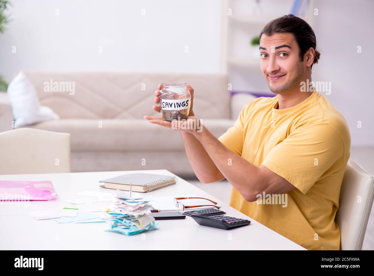 Young man in the budget planning concept Stock Photo - Alamy