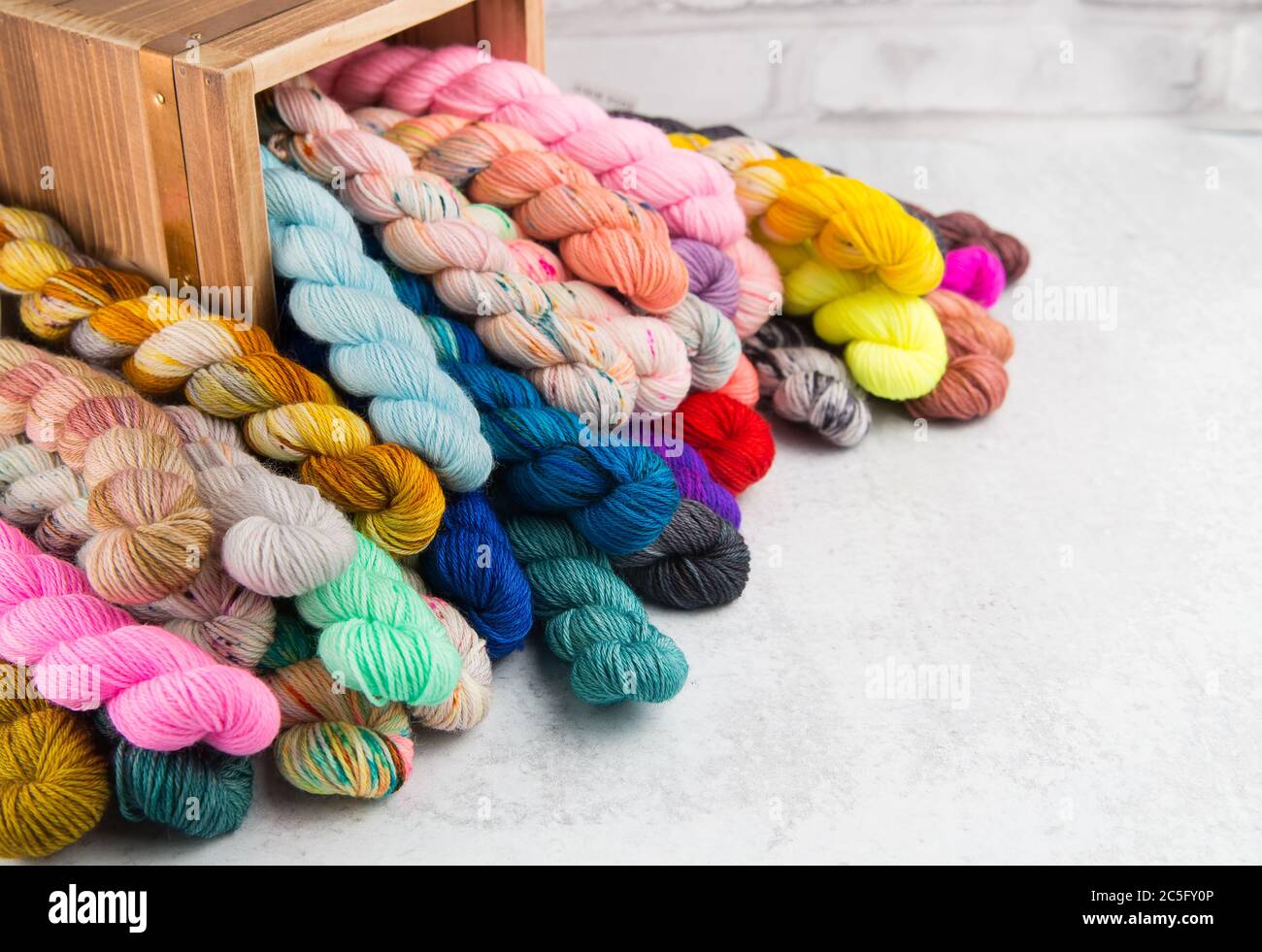 Colorful twists of yarn are stacked on a table Stock Photo - Alamy