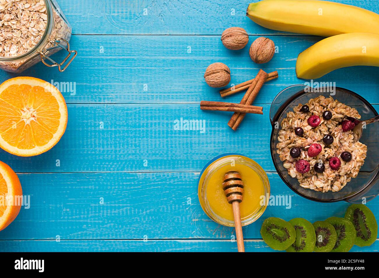 Breakfast with oatmeal, berries, honey, fruits and nuts. Space for text ...