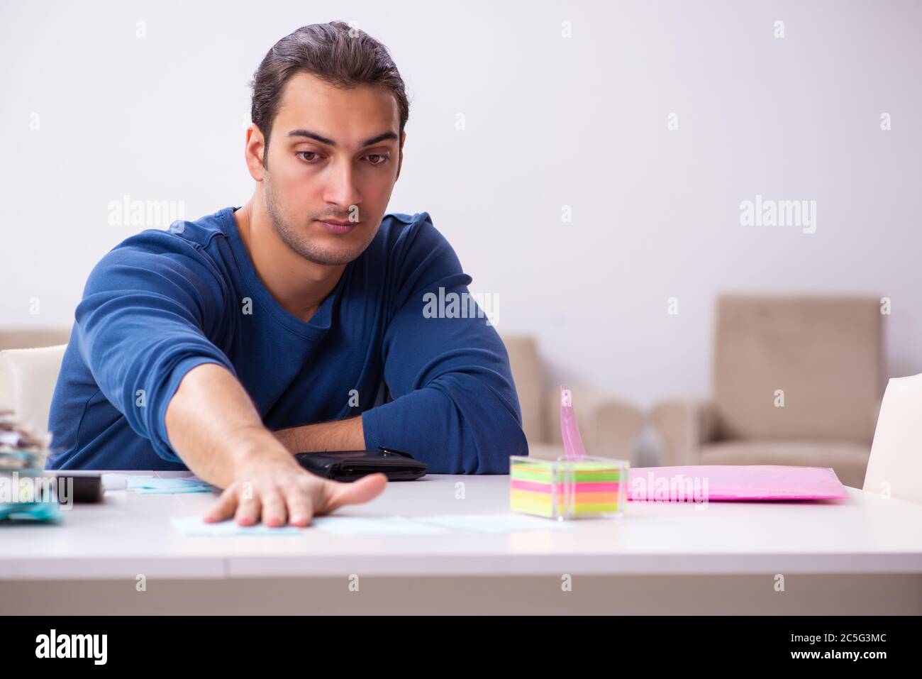 Young man in the budget planning concept Stock Photo - Alamy