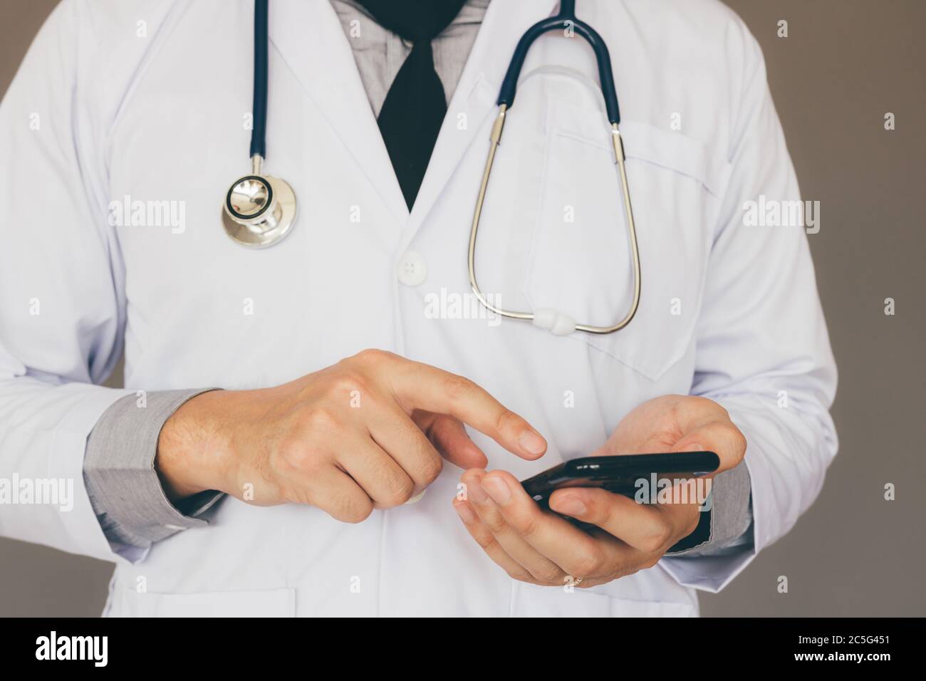 Doctor using smartphone and typing to screen Stock Photo - Alamy