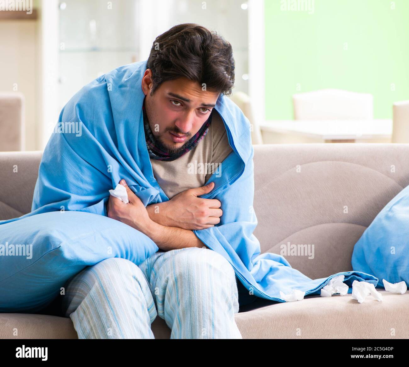 The sick young man suffering from flu at home Stock Photo - Alamy