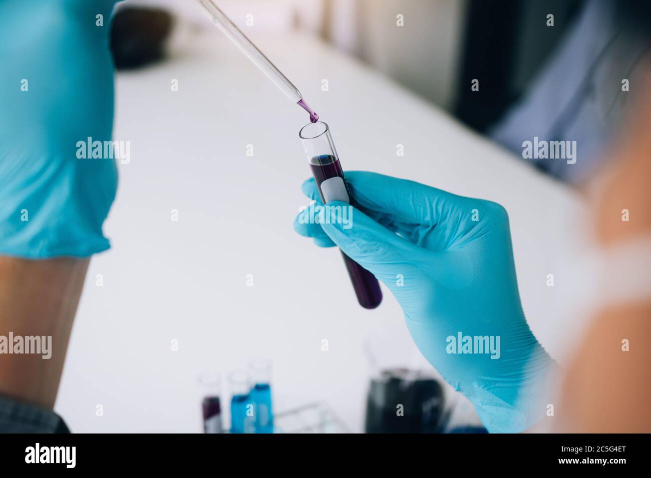 Chemist scientist conducts experiments by synthesising compounds with ...