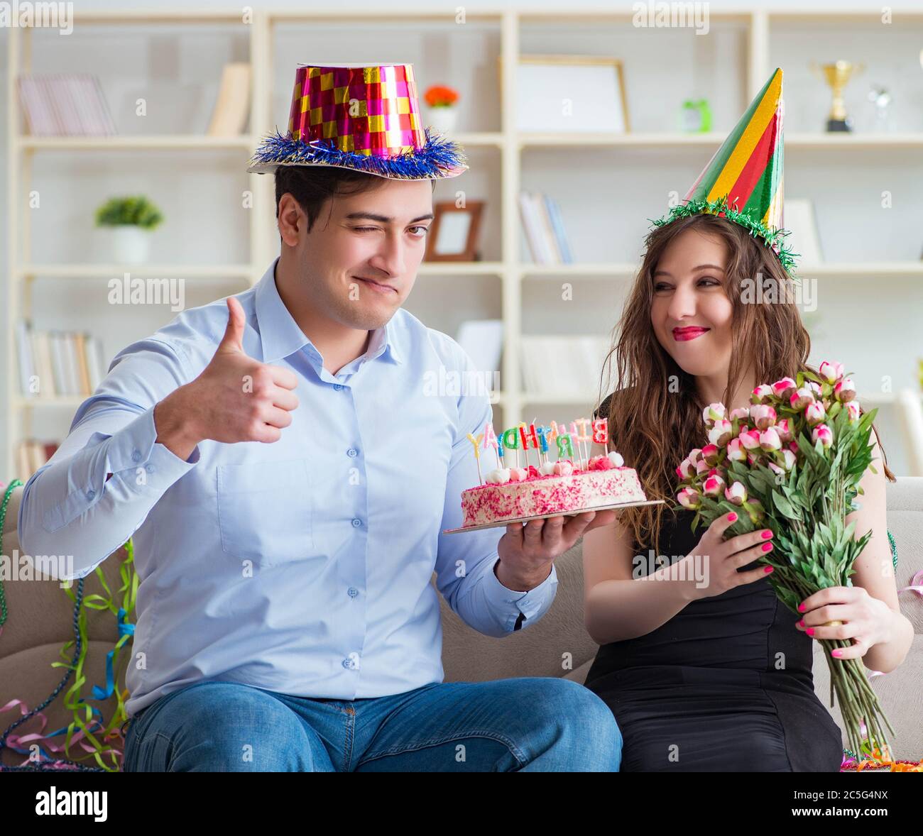 The young couple celebrating birthday with cake Stock Photo - Alamy
