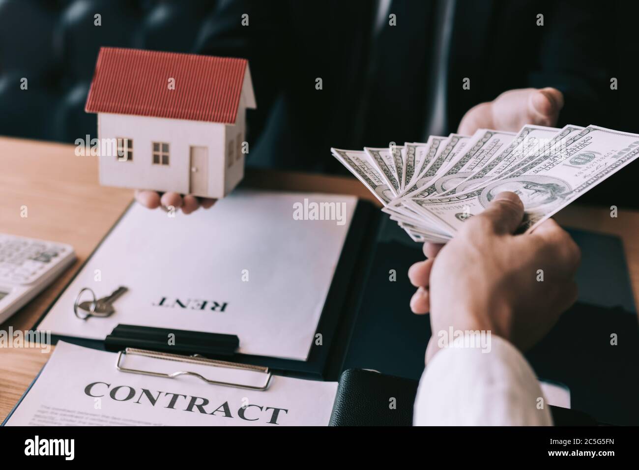 Businessman handed the house model and new homeowner giving money to ...