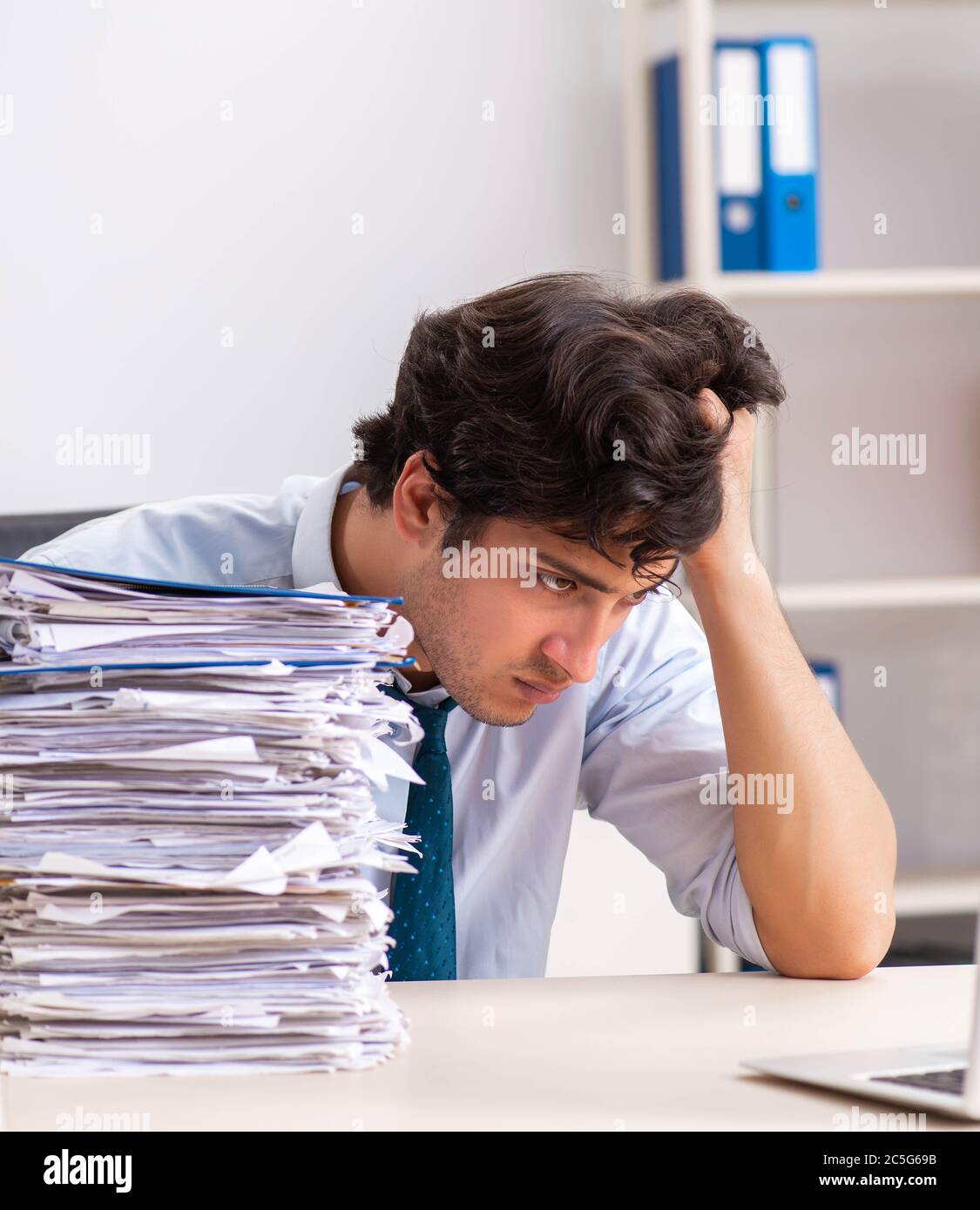 The overloaded busy employee with too much work and paperwork Stock ...