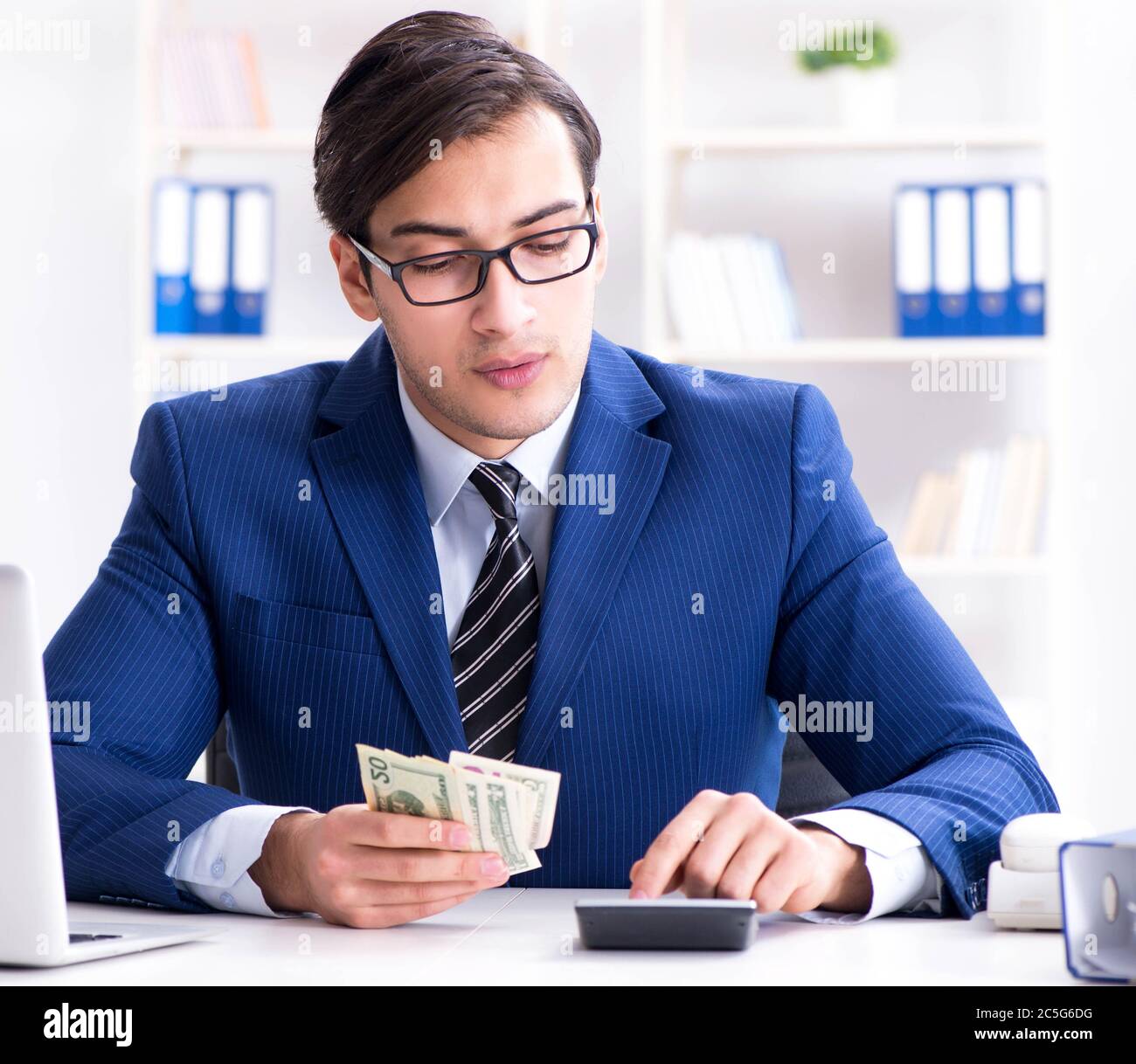 The accountant calculating dollars with calculator in office Stock ...