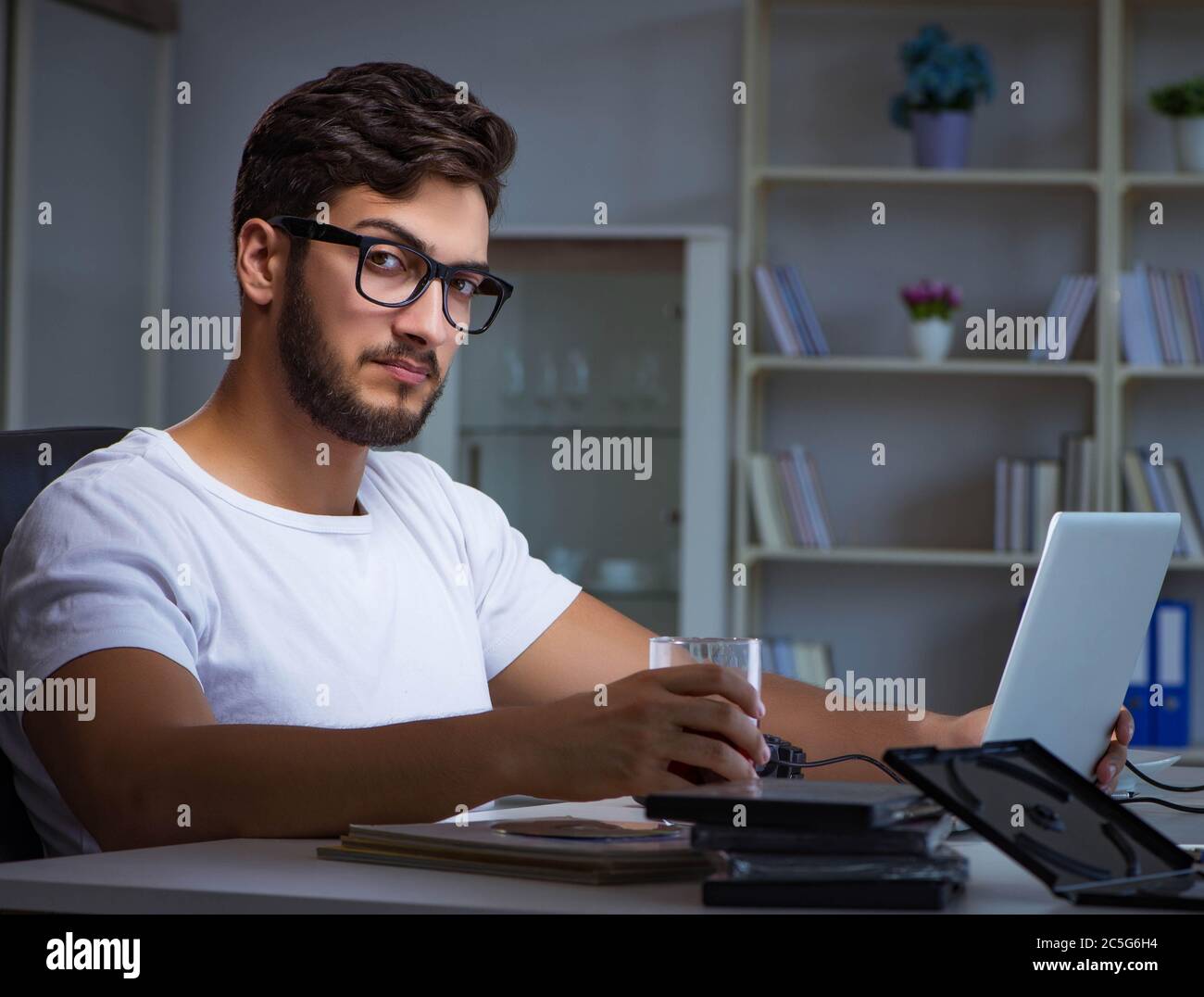 The young man staying late in office to do overtime work Stock Photo ...