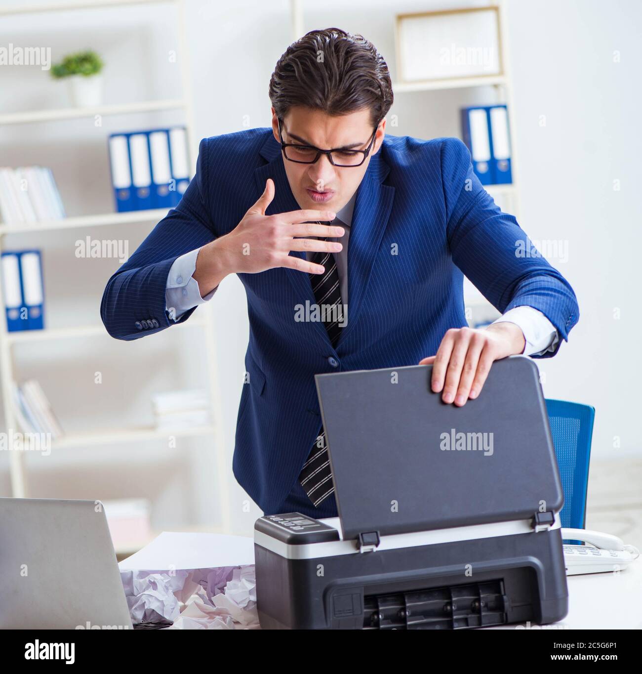 The businessman angry at copying machine jamming papers Stock Photo - Alamy
