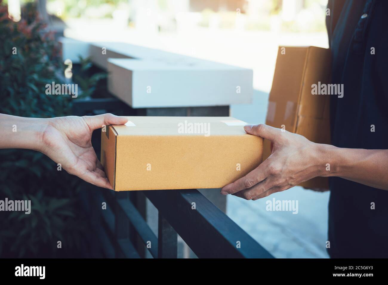 Asian smart man handing giving a package to a customer Stock Photo - Alamy