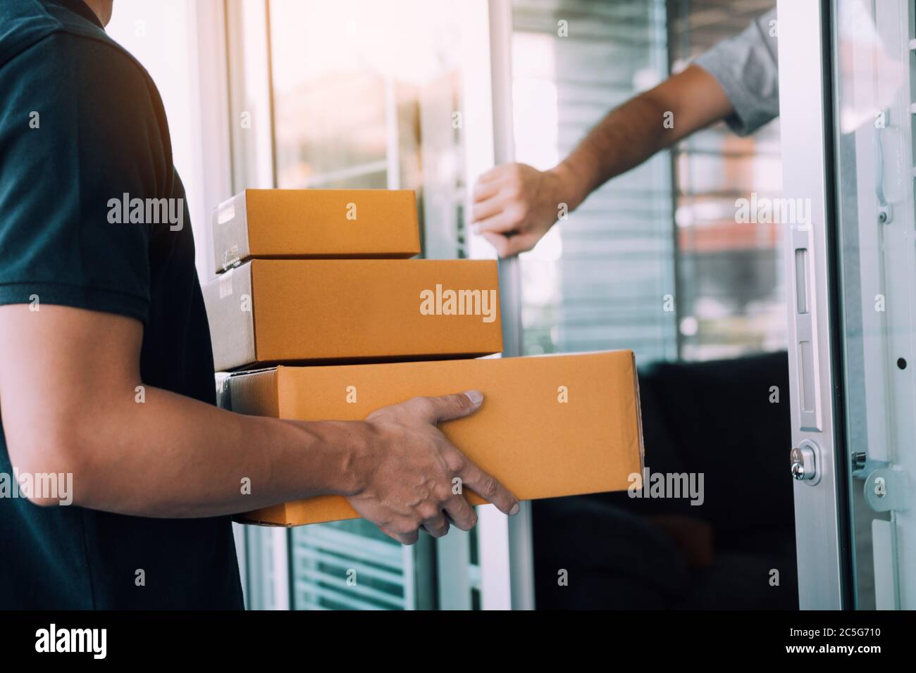 Close up of hand recipient of the goods is opening the house door to ...