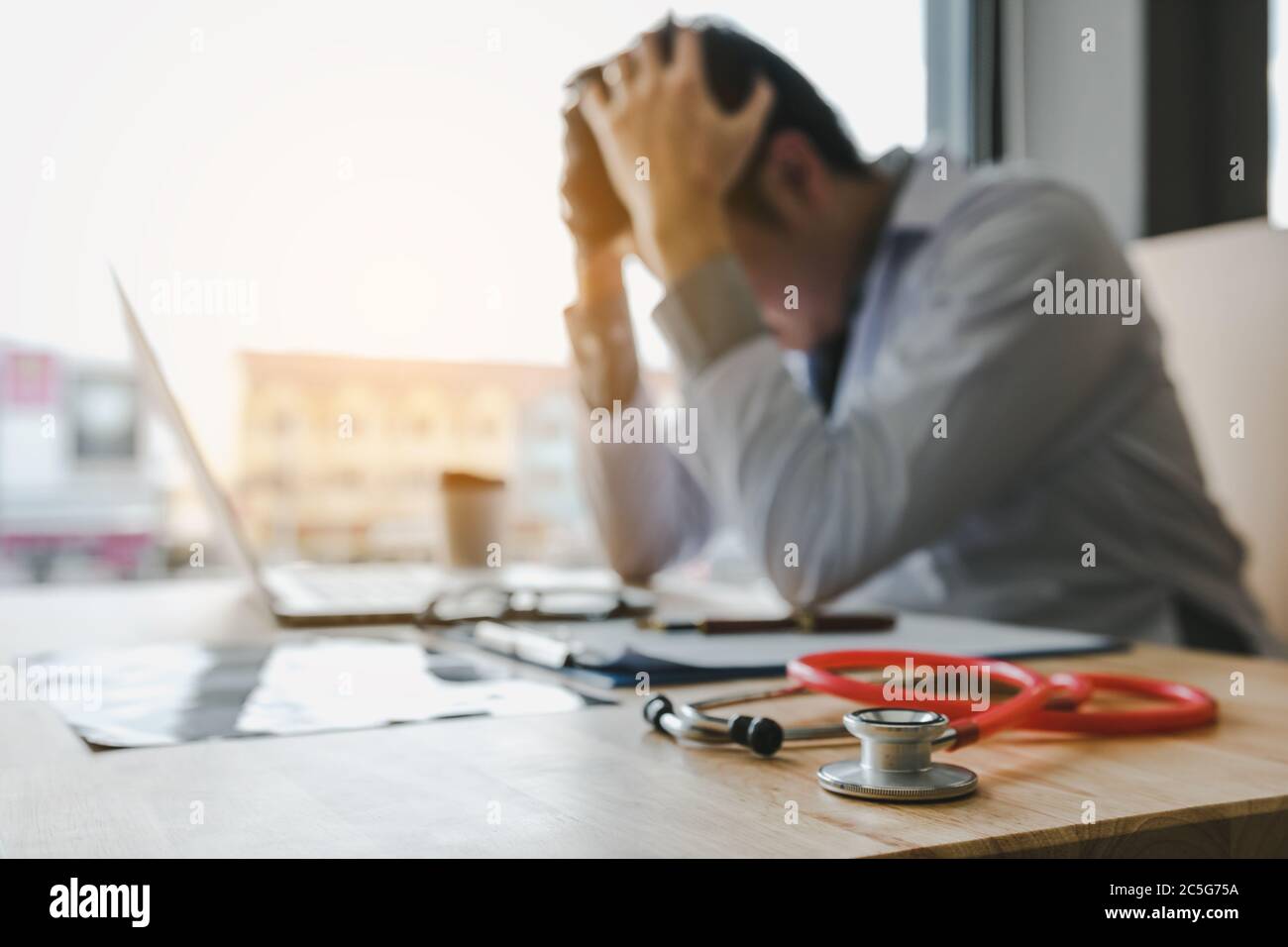 Young man doctor being exhausted in the office room Stock Photo - Alamy