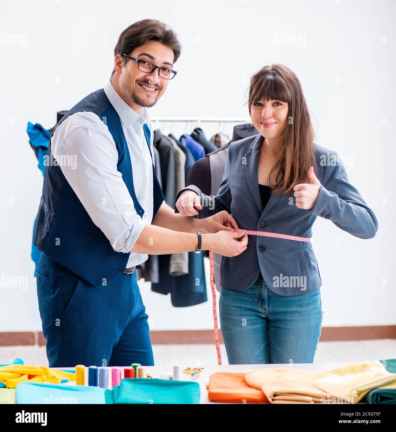 The professional tailor taking measurements for formal suit Stock Photo ...