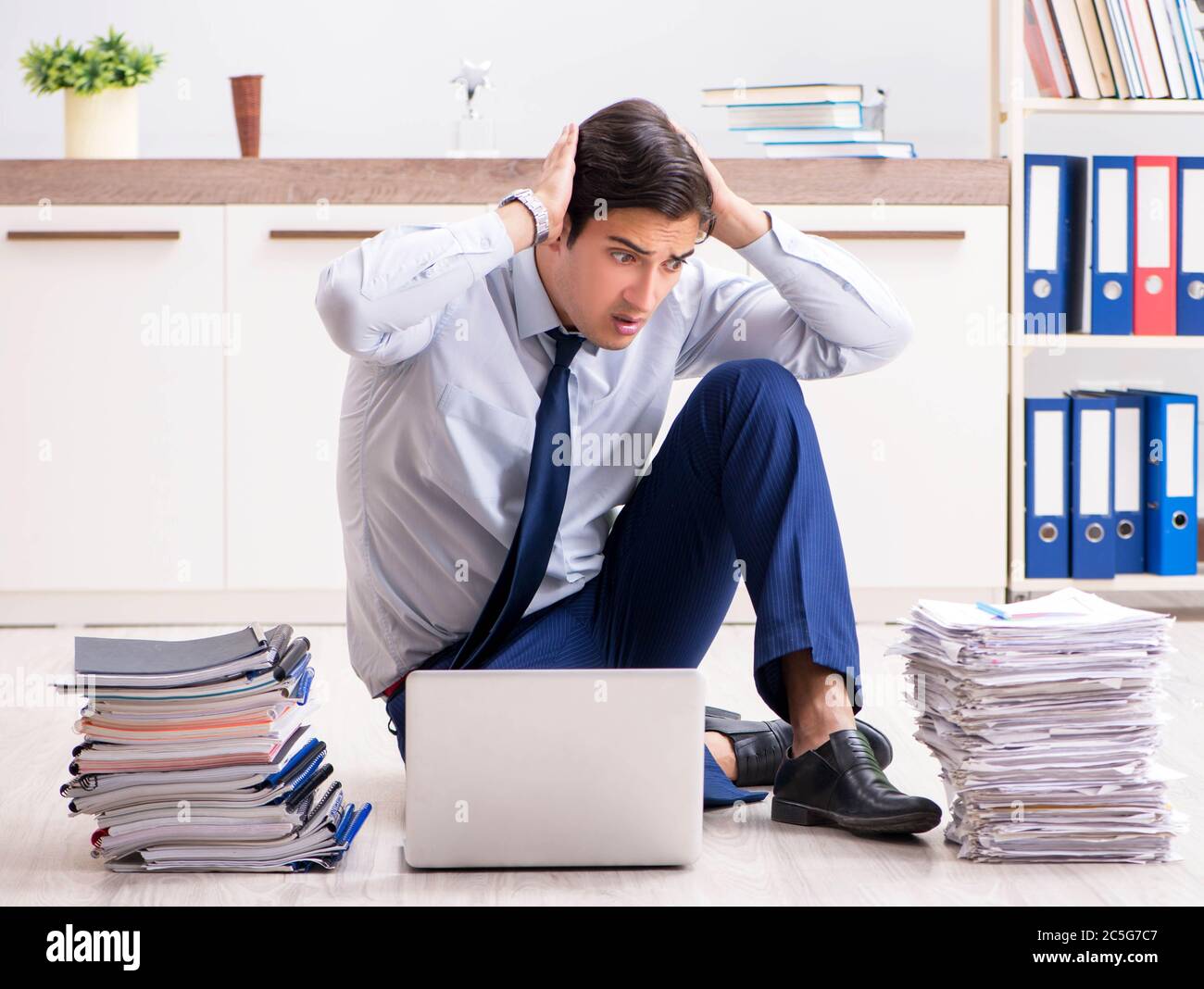 The extremely busy employee working in the office Stock Photo - Alamy