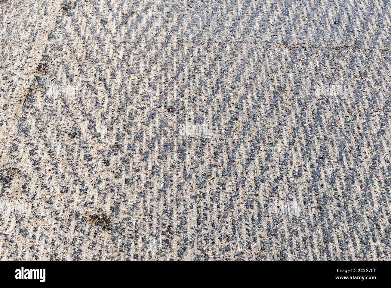The surface of a road that has been scraped in preparation for re ...